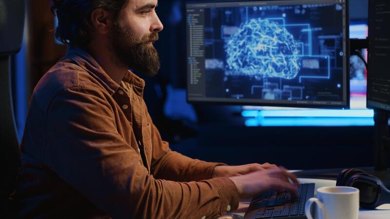 Computer scientist updating artificial intelligence neural networks, drinking coffee and writing ...