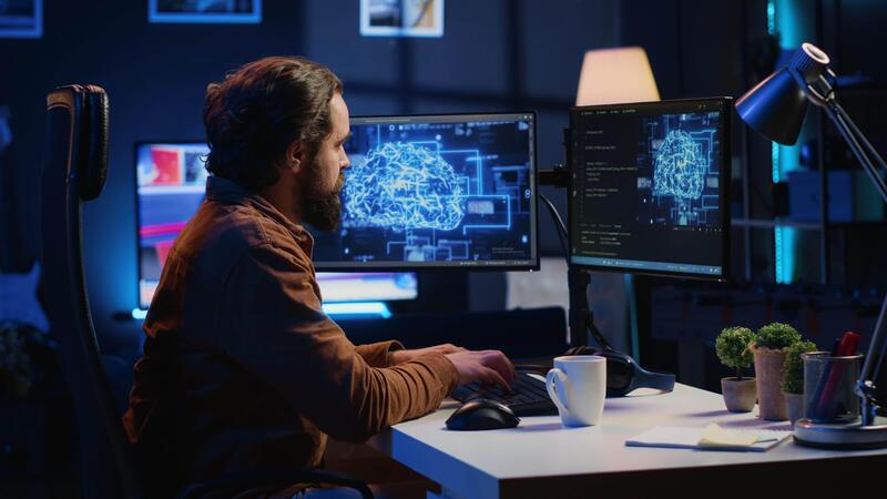 Developer updating artificial intelligence neural networks, typing on computer keyboard and ...