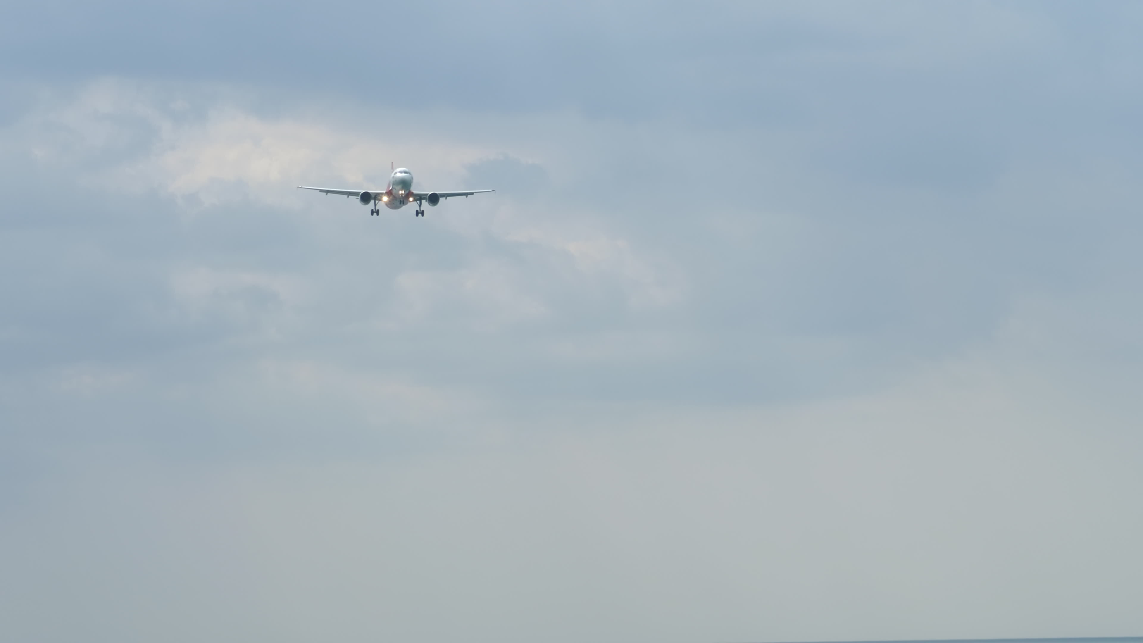 Passenger plane landing, long shot, front view. Jet plane approaching ... Passenger plane landing, long shot, front view. Jet plane approaching ...