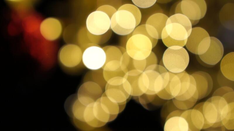 Abstract festive yellow-orange lights with bokeh, sparkling circular stars motion. Holiday ...