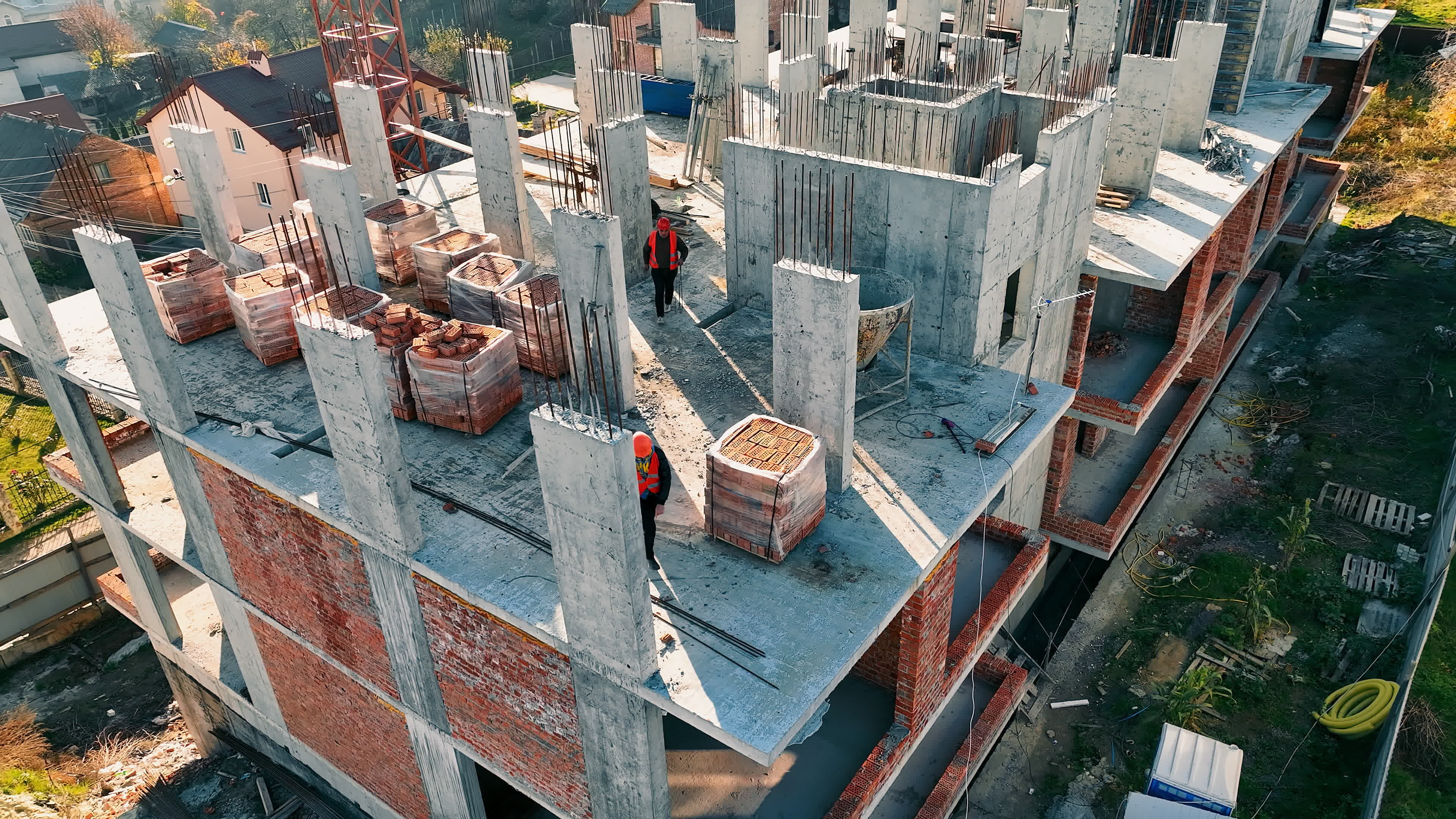 Aerial view Construction works. Builders are building another floor of a multi-story brick ...