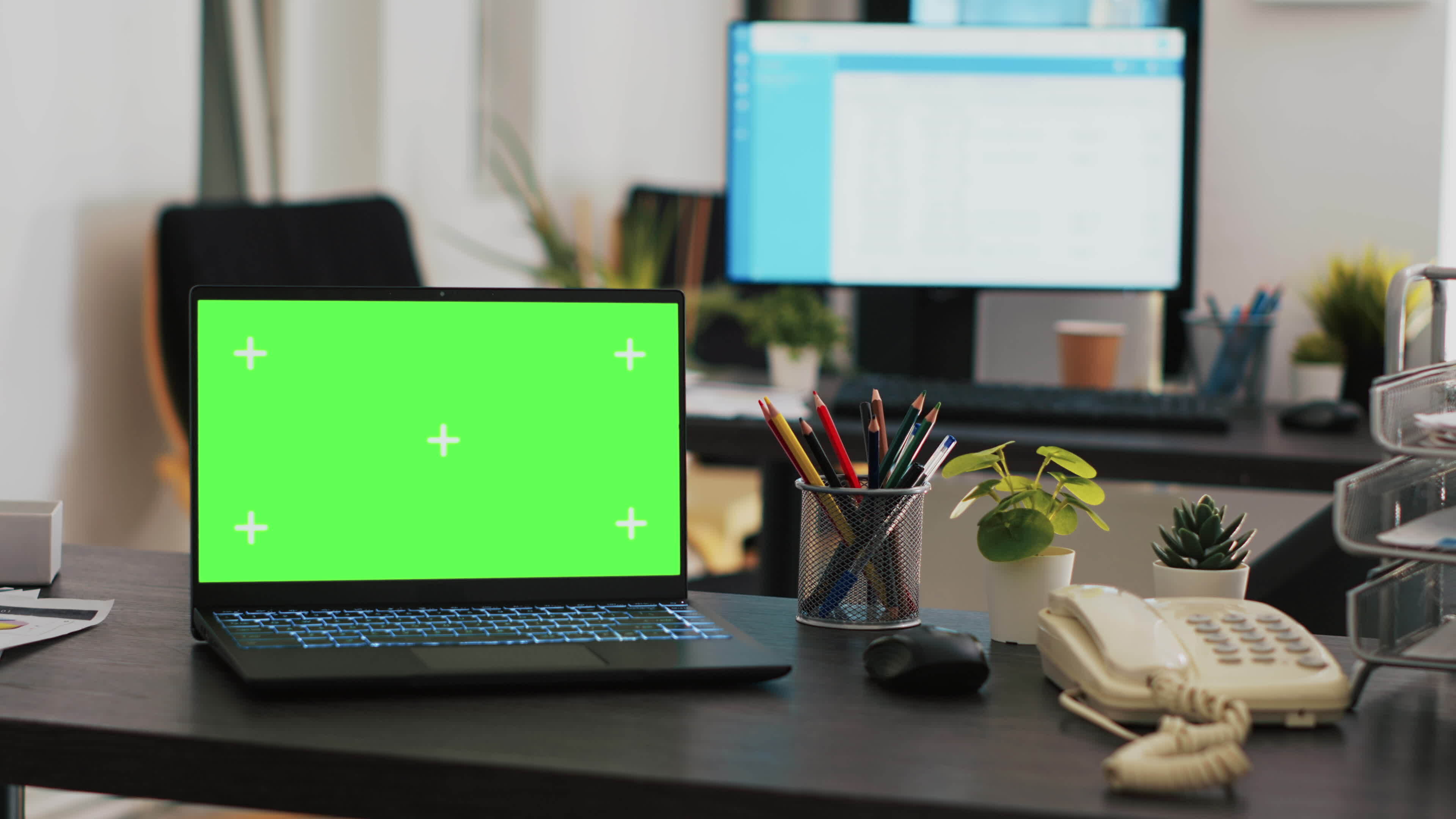 Office with isolated screen laptop and display in background with ...