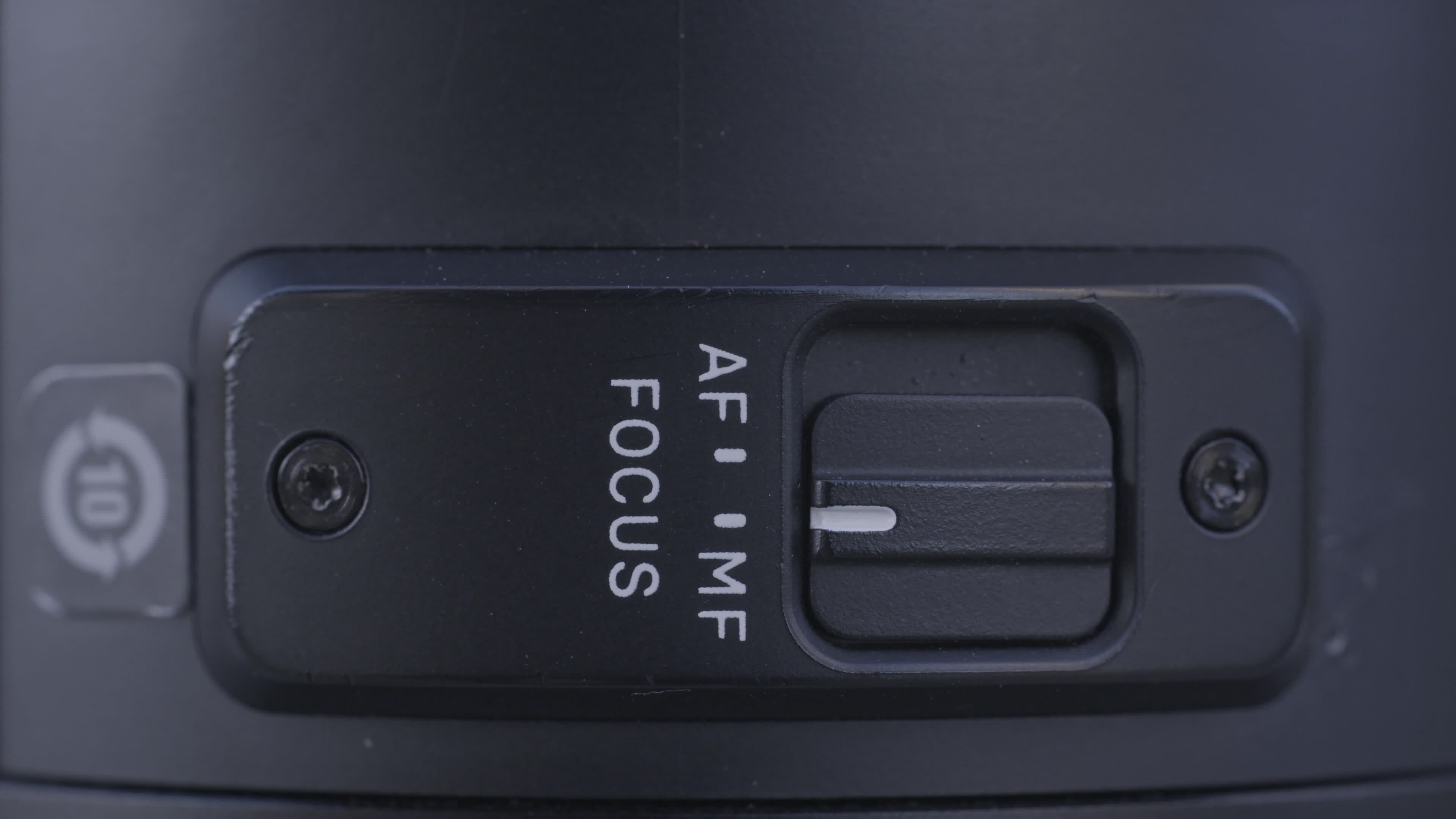Extreme close up of camera lens details. Action. Manual MF and auto AF focus switch button on ...