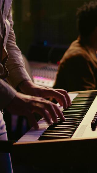 Vertical Musician Playing Piano Midi Controller In Control Room At