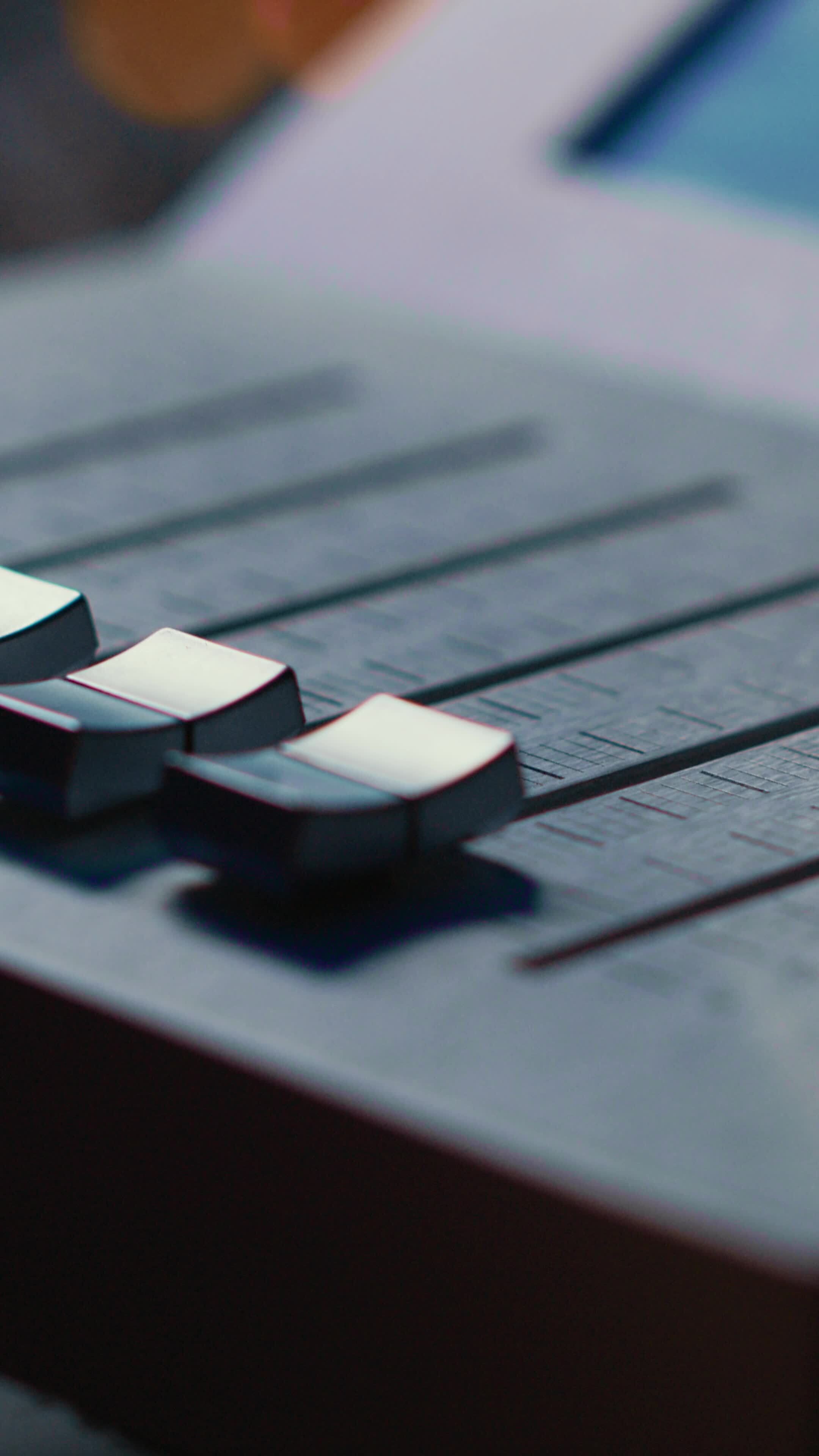 Vertical Sound Engineer Operating On Motorized Faders Controller In