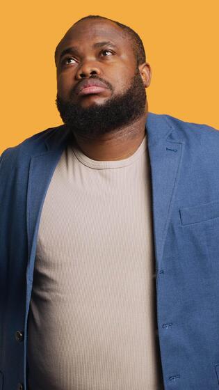 Vertical African american man shrugging shoulders, not caring, having ...