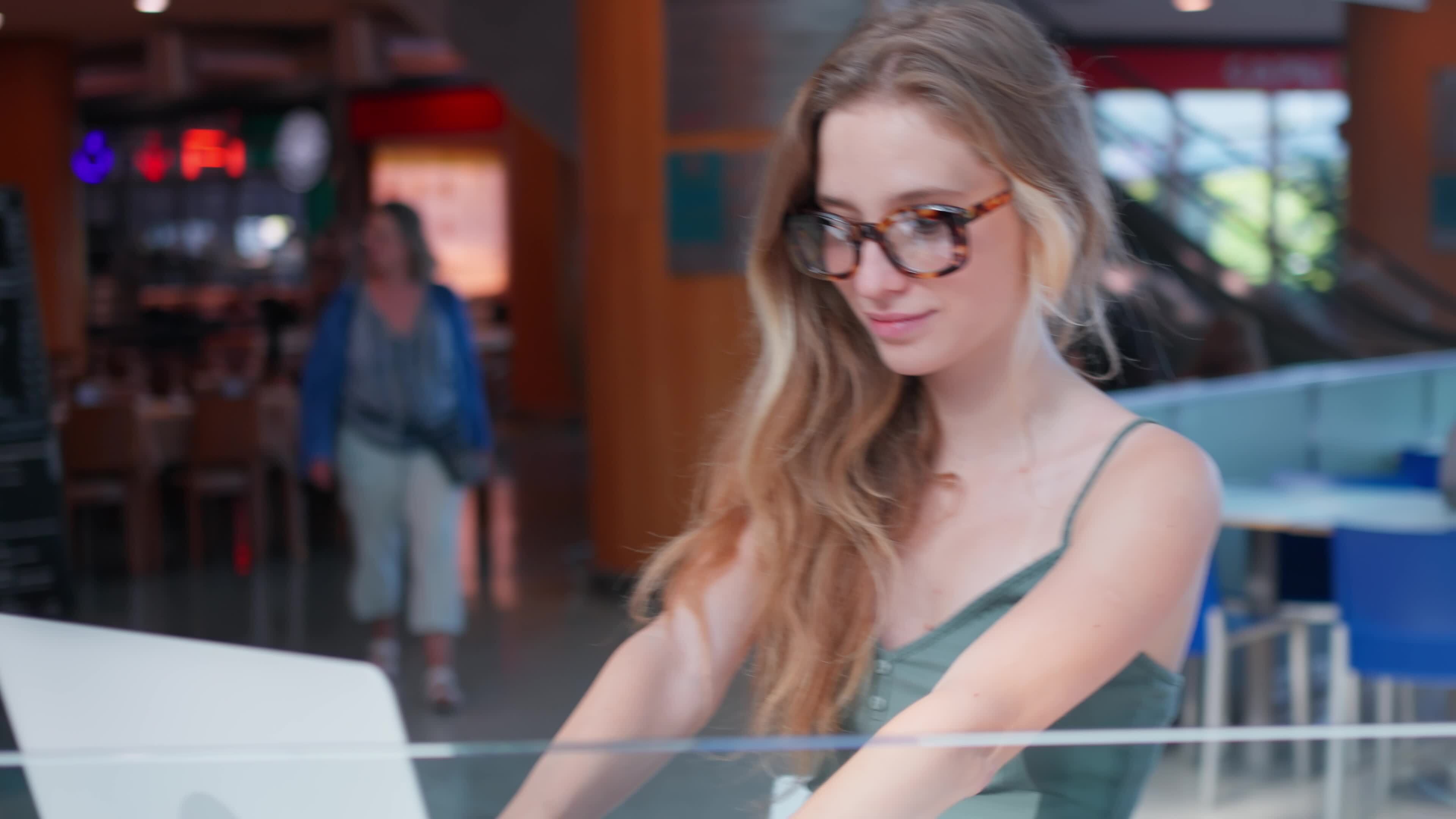 a woman in glasses sitting while working on her laptop 43425969 Stock ...