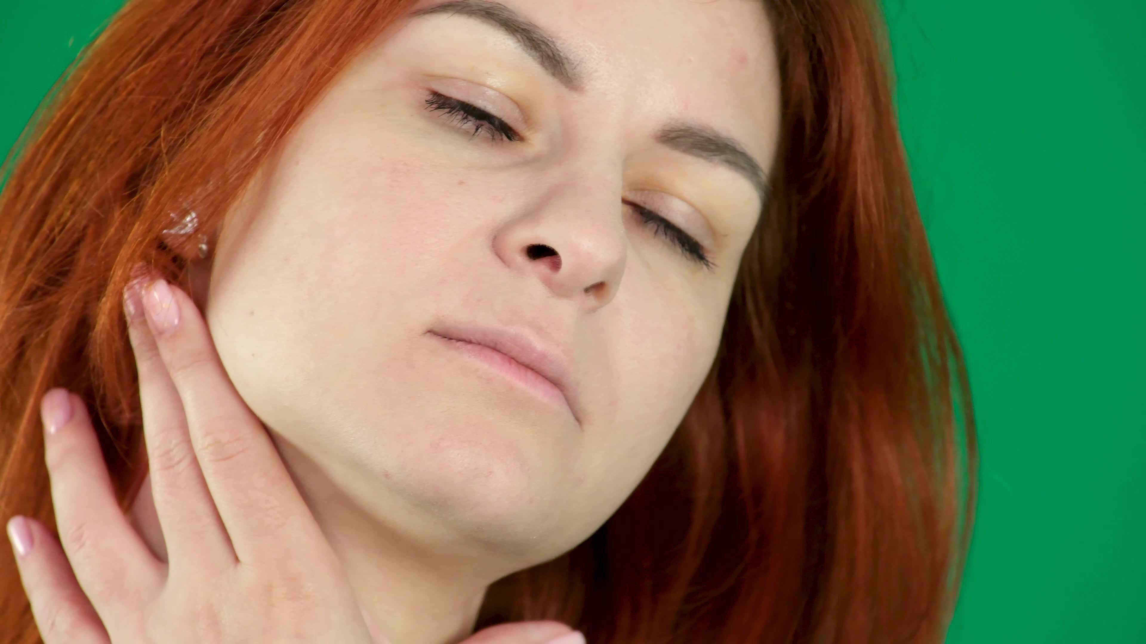 The Red Haired Girl Touches Her Throat Neck With Her Hand On A Green Background 4k 44181149