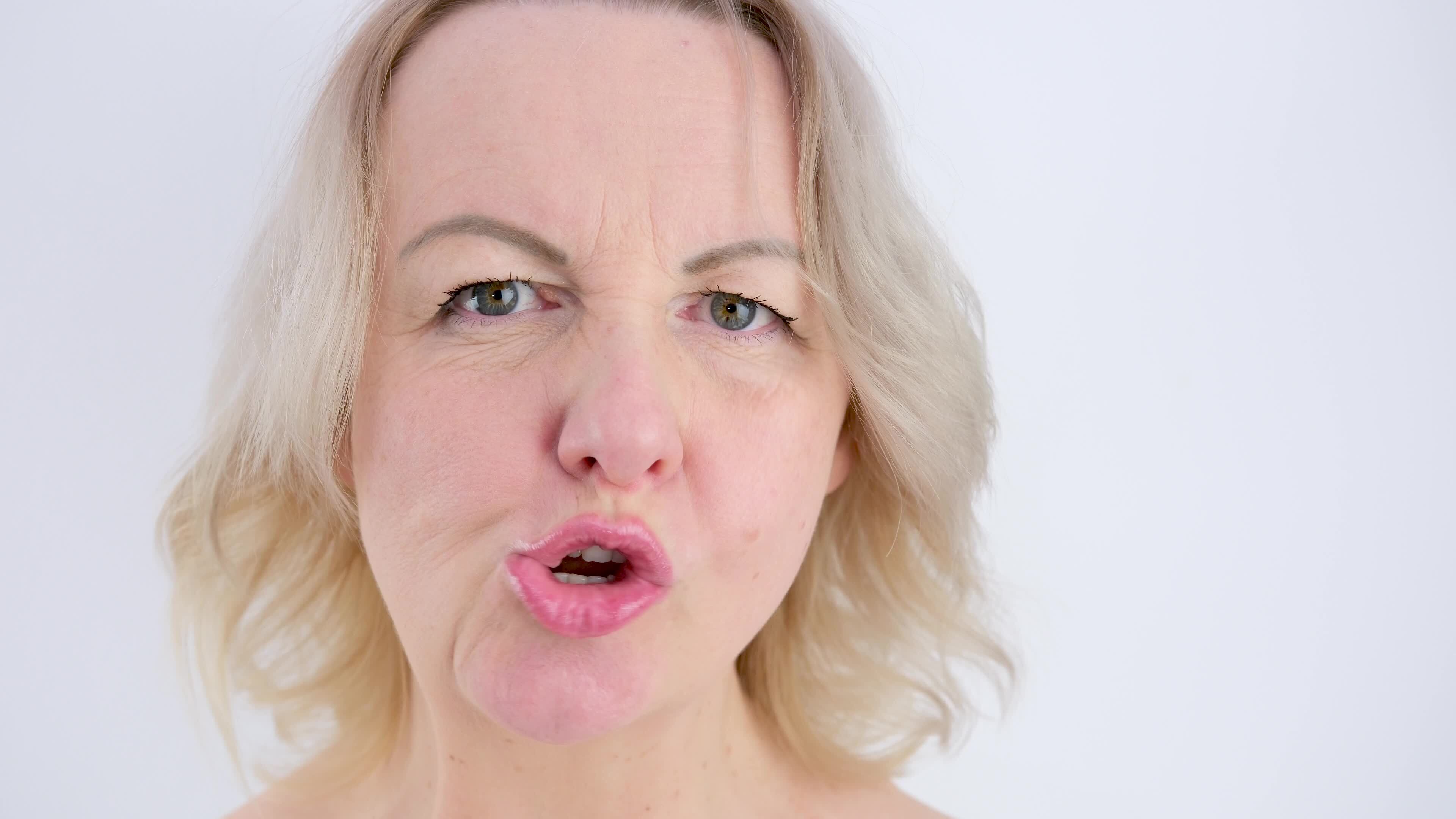 the girl builds dissatisfied grimaces with her mouth lips teeth moves in different directions ...