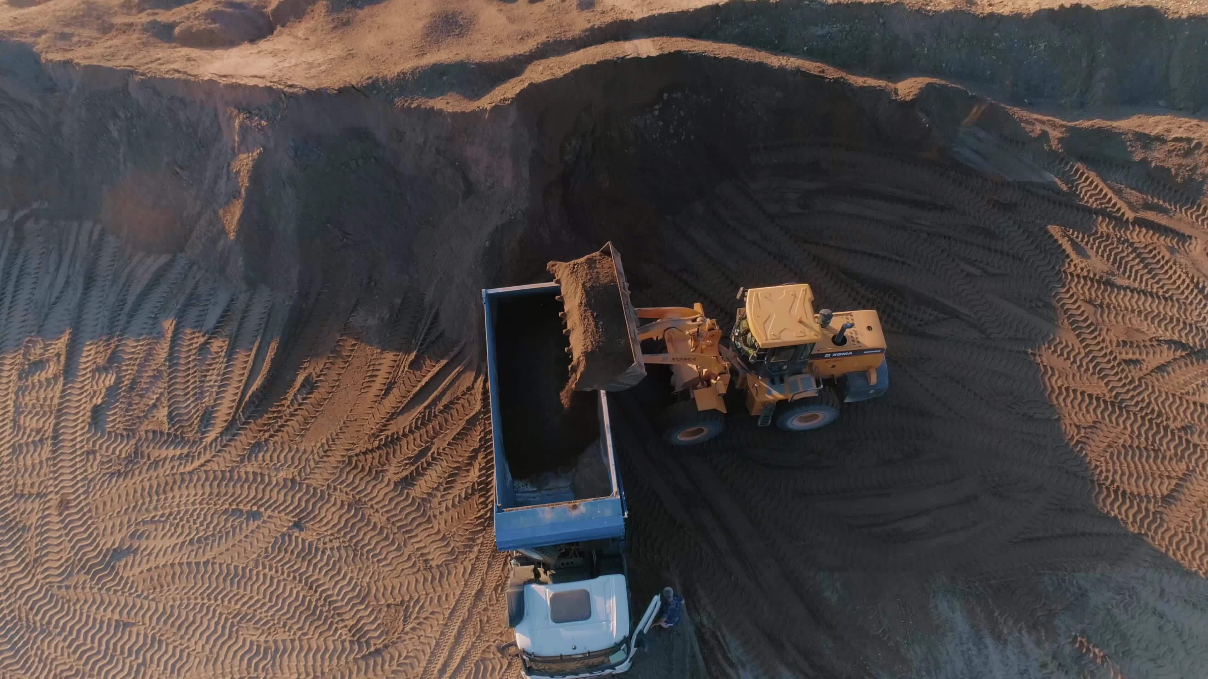 Haut vue de excavatrice avec déverser un camion à carrière. scène. excavatrice remplit déverser ...