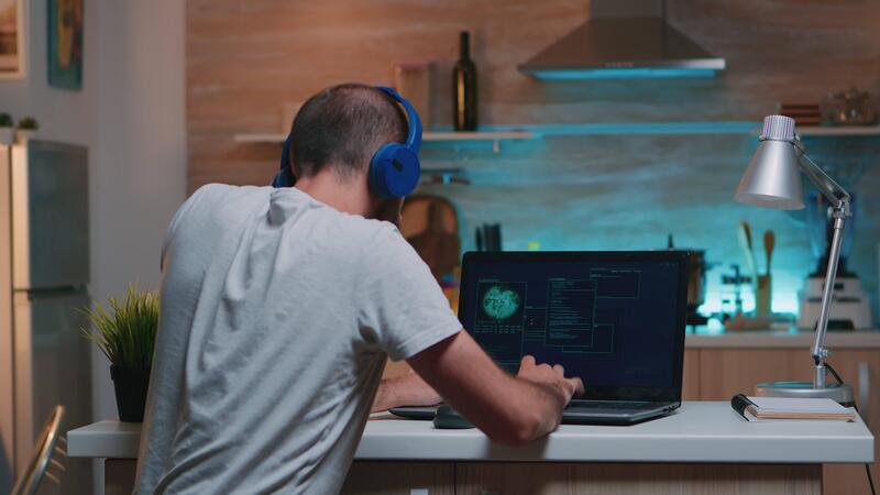 Man Hacker With Headset Coding Html And Programming On Screen Laptop Working From Home In