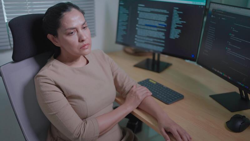 Close-up of a self-employed woman sitting and writing code, discouraged ... Close-up of a self-employed woman sitting and writing code, discouraged ...
