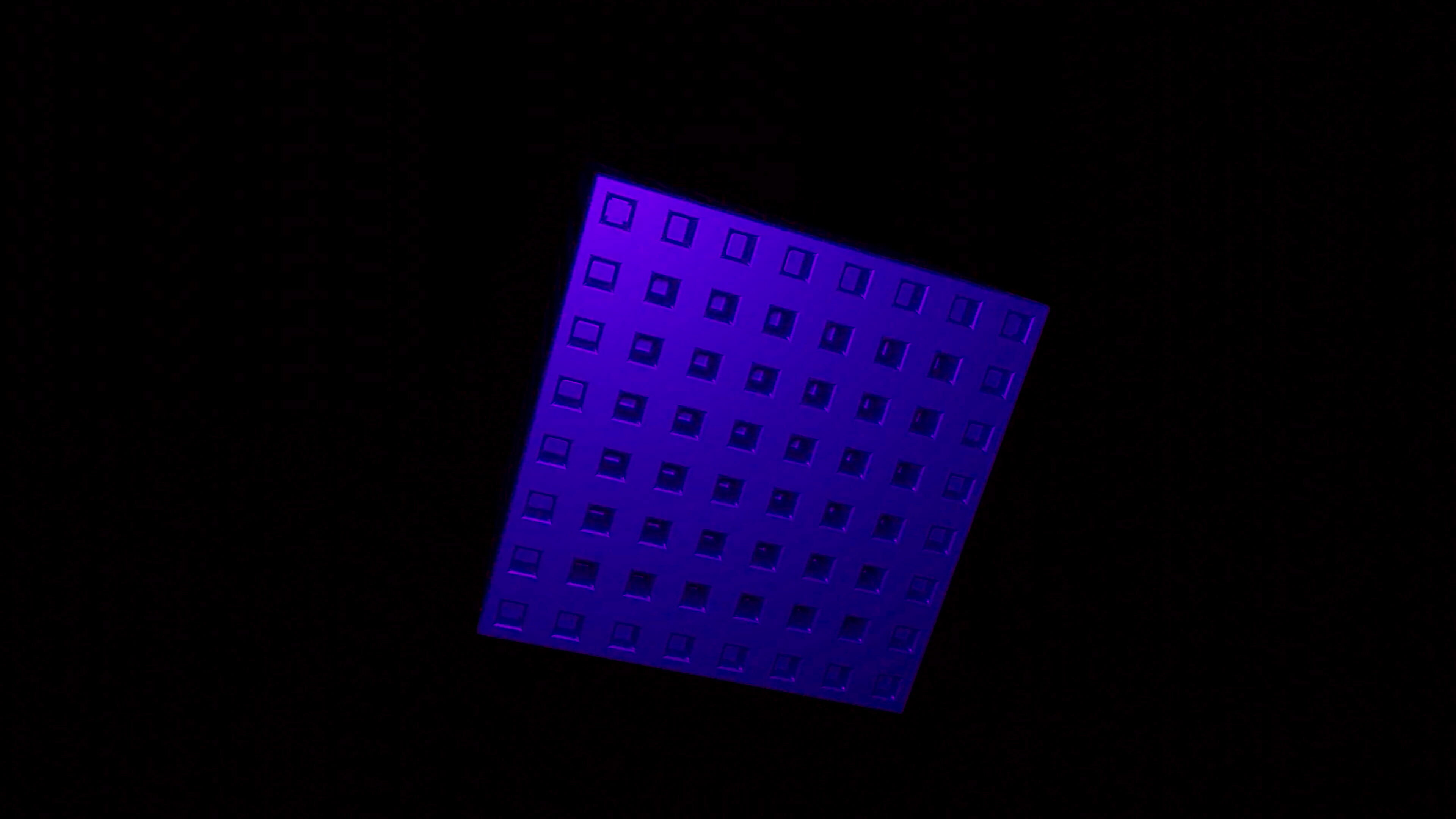 Close up of blue 3D cube rotating isolated on a black background ...