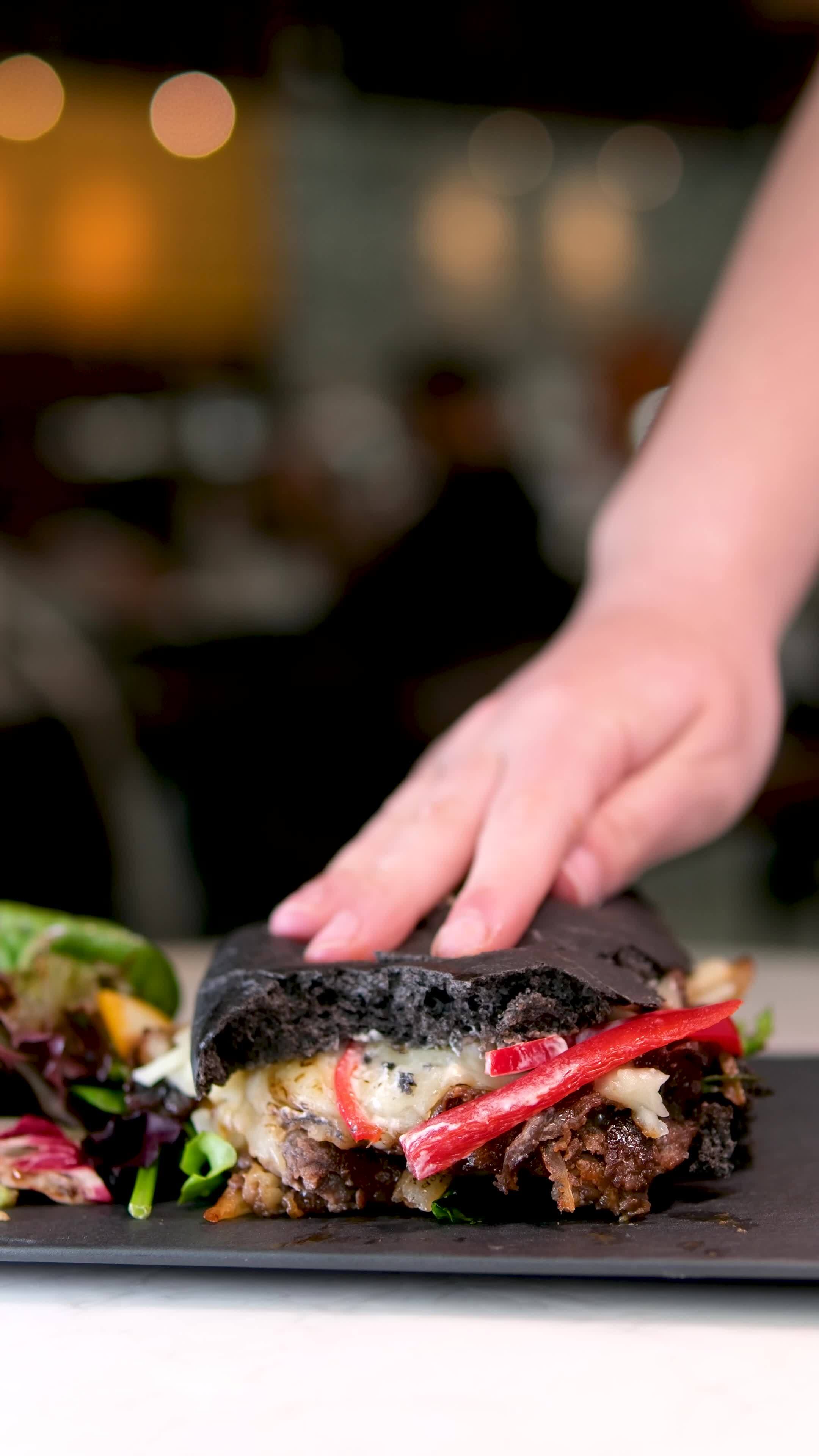 mão pressionando em delicioso sanduíche com Preto pão uma muitos do o preenchimento Pimenta ...