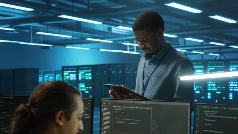 IT expert in server hub ensuring valuable data remains shielded from potential threats using ...