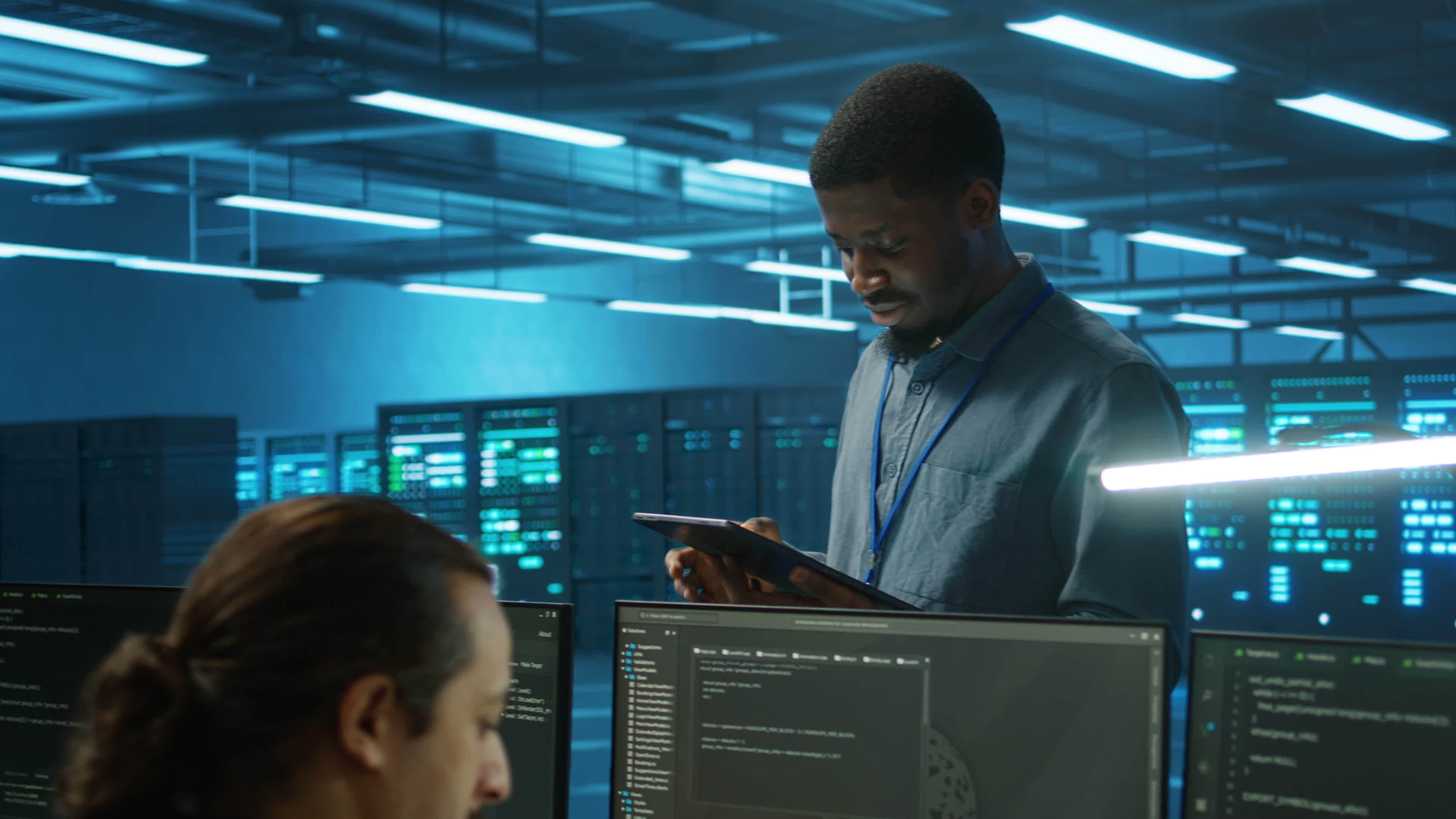 IT expert in server hub ensuring valuable data remains shielded from potential threats using ...