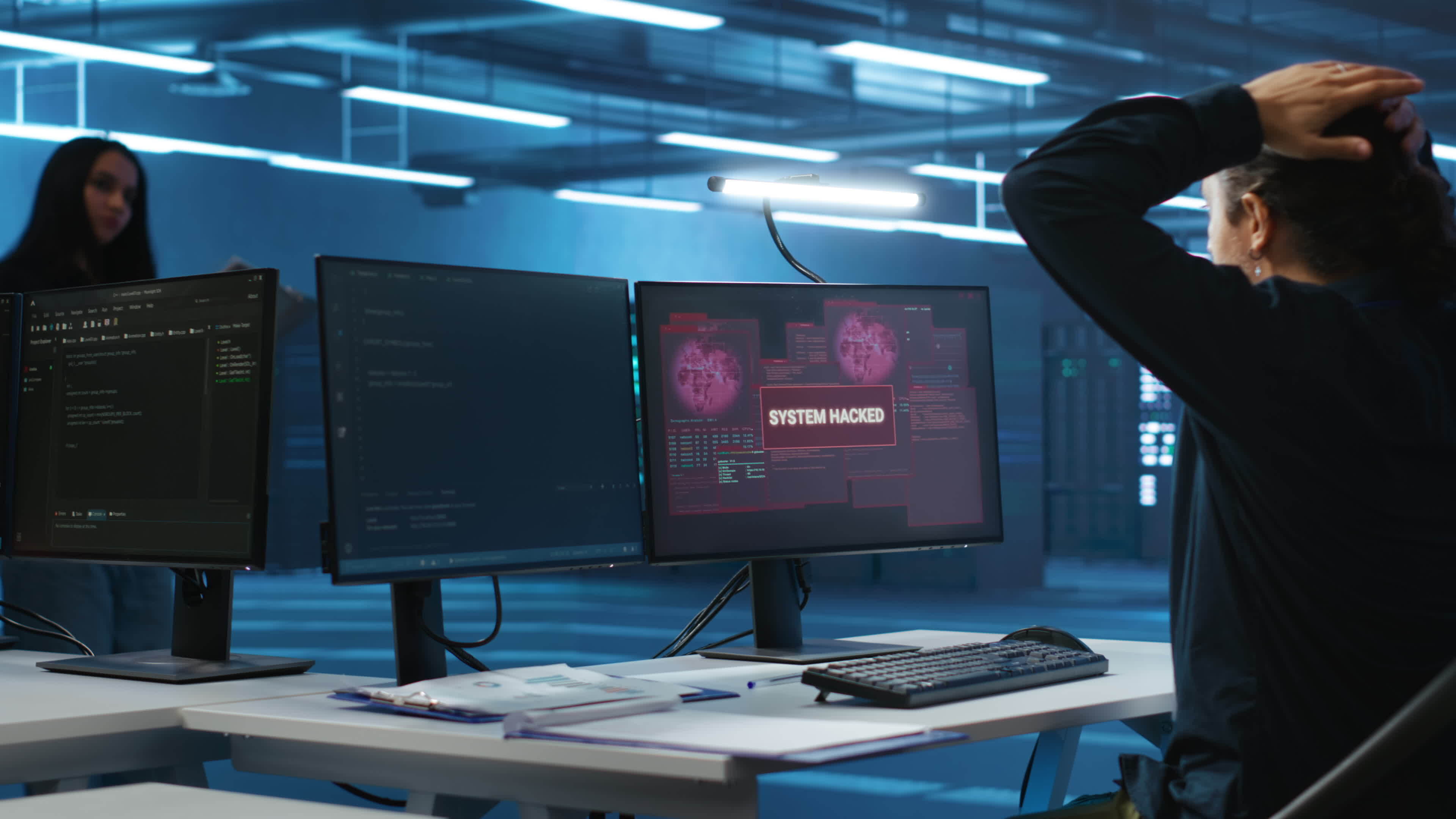 Programmer in server hub workspace requesting assistance from colleagues during hacking attack ...