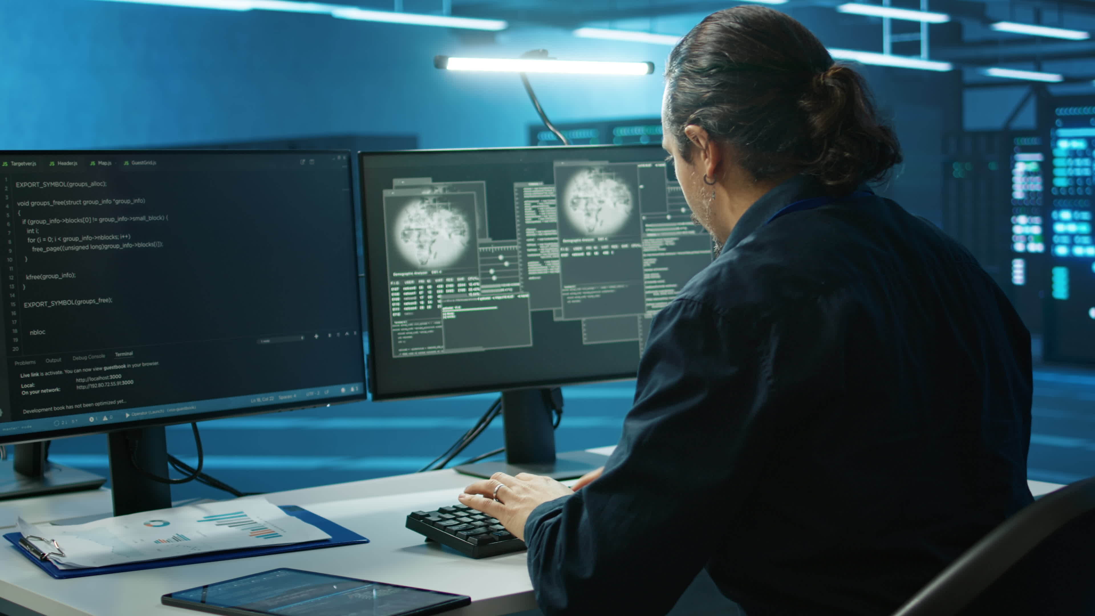 System administrator in server room frightened by sensitive data threatened by hacking attack on ...