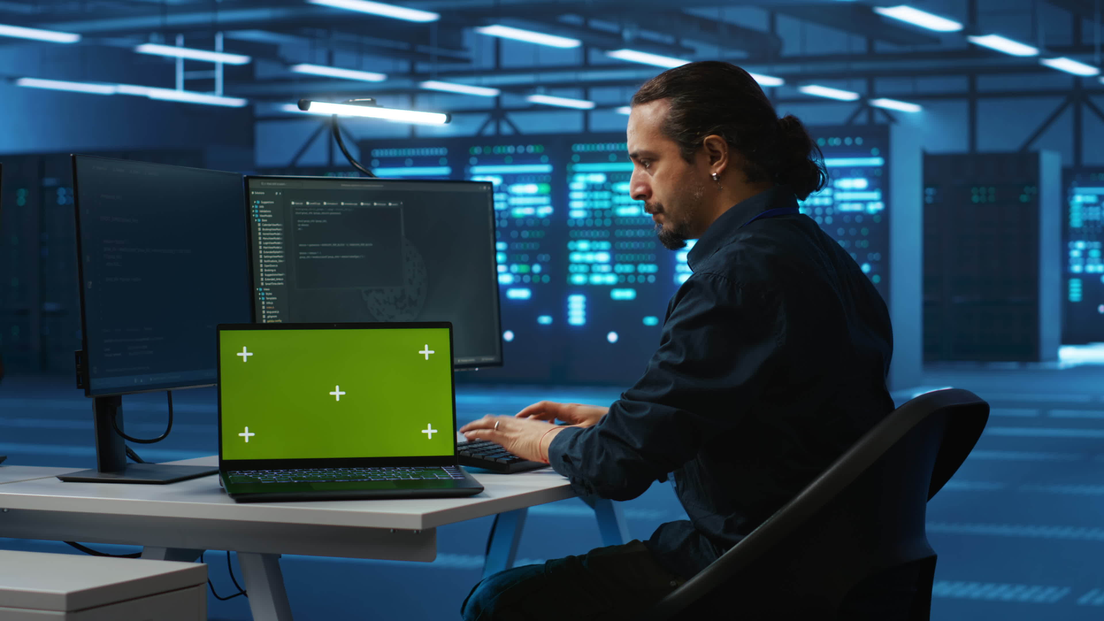 Engineer upgrading equipment in data center using green screen laptop ...