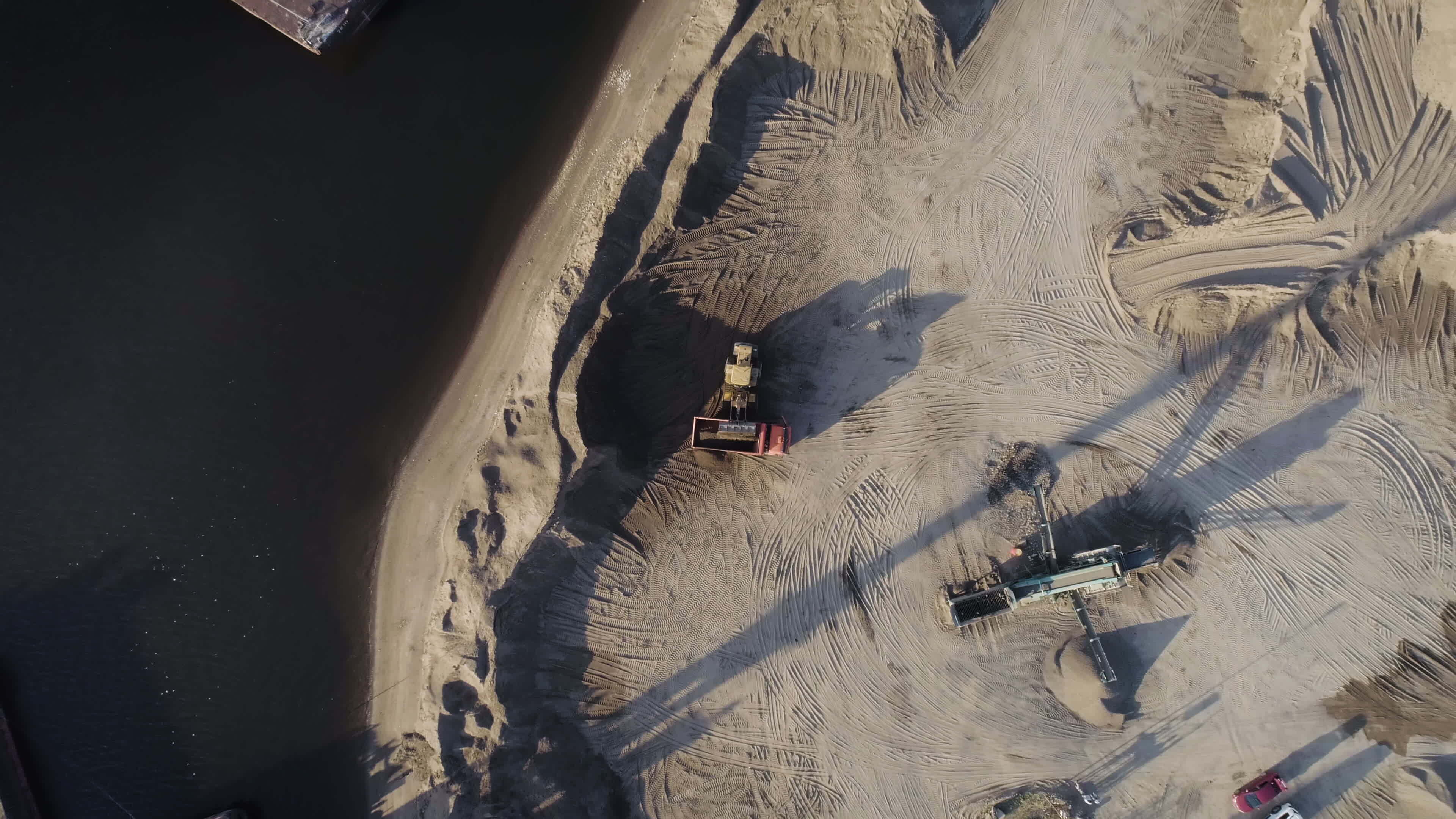 Aerial top view of trucks and machinery in the sand quarry. Scene. Sand pit, loading wagon sand ...