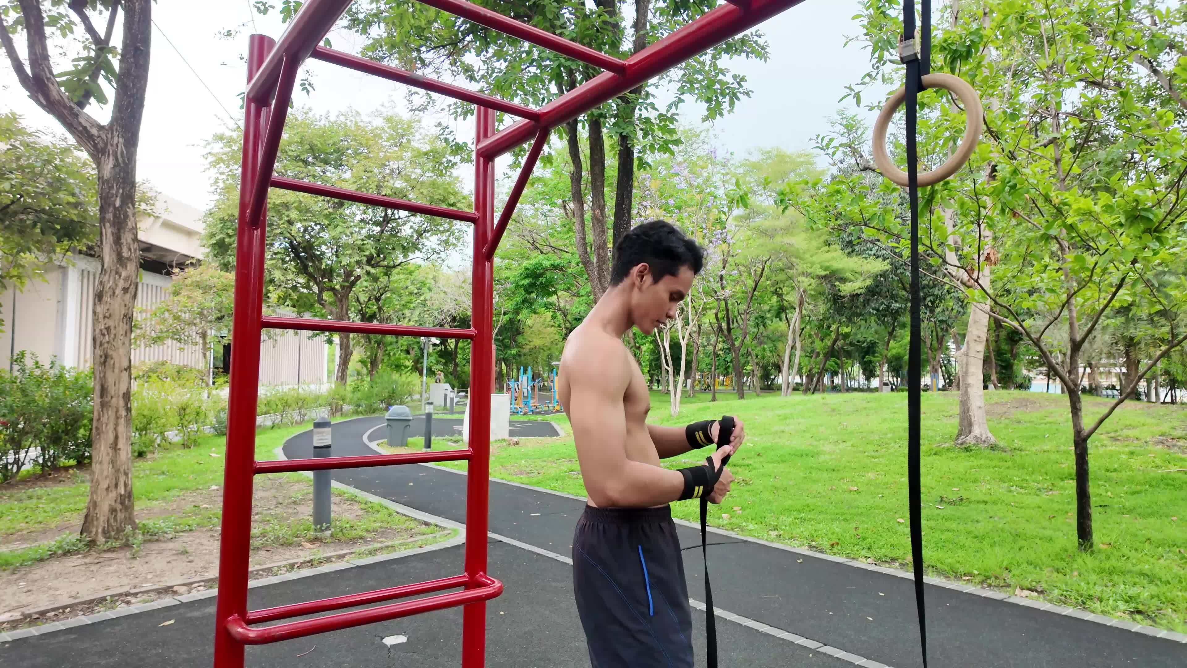 Asian Man Practicing Gymnastics Doing Gymnastics Bar And Hoop Exercises And Stretching And