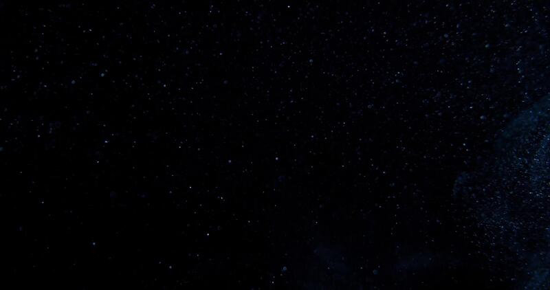 Cinematic dust particles floating on Black Screen Overlay. RED camera footage in slow motion ...