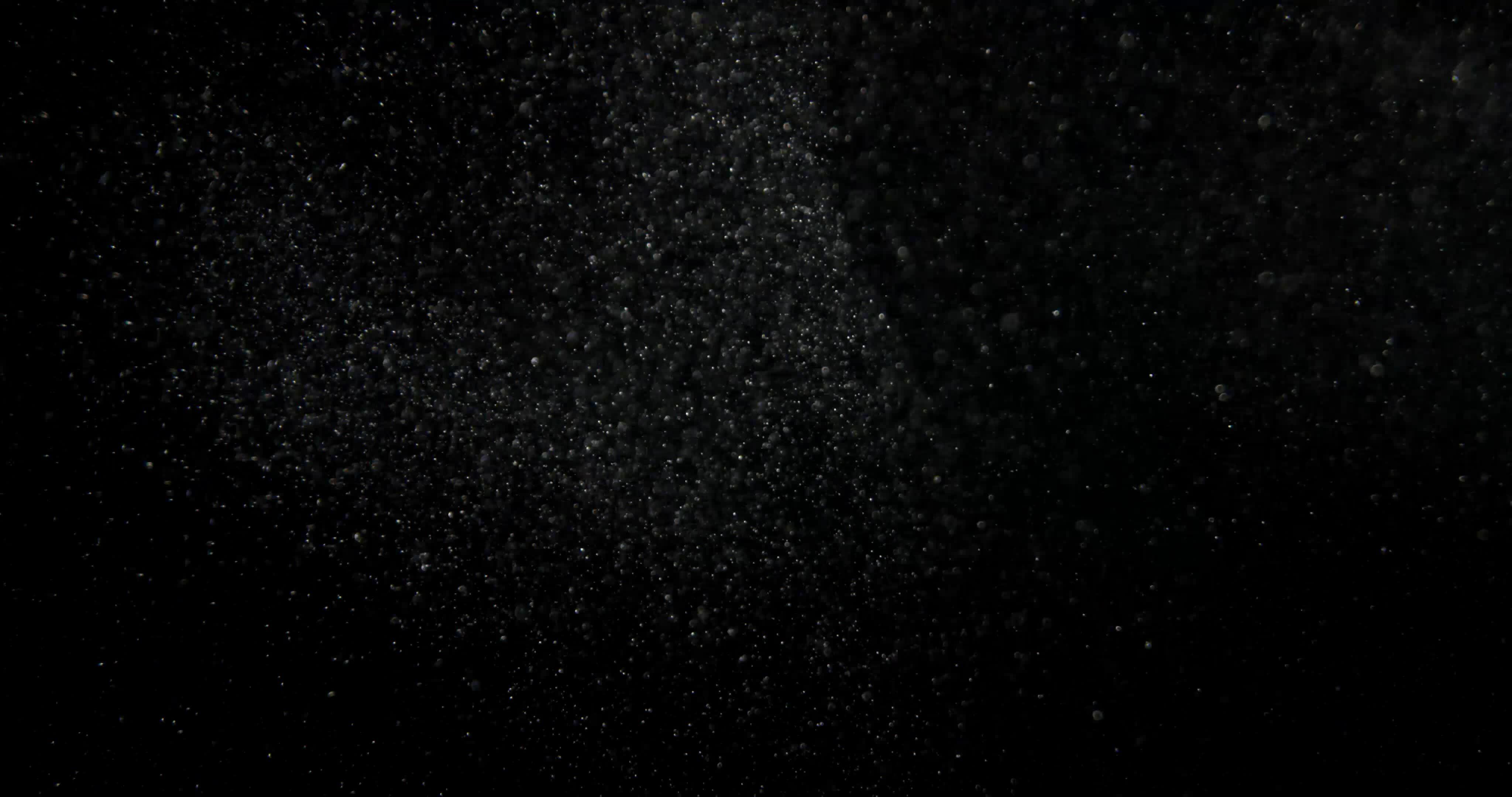 Cinematic dust particles on black screen overlay. Filmed with RED camera in slow motion ...