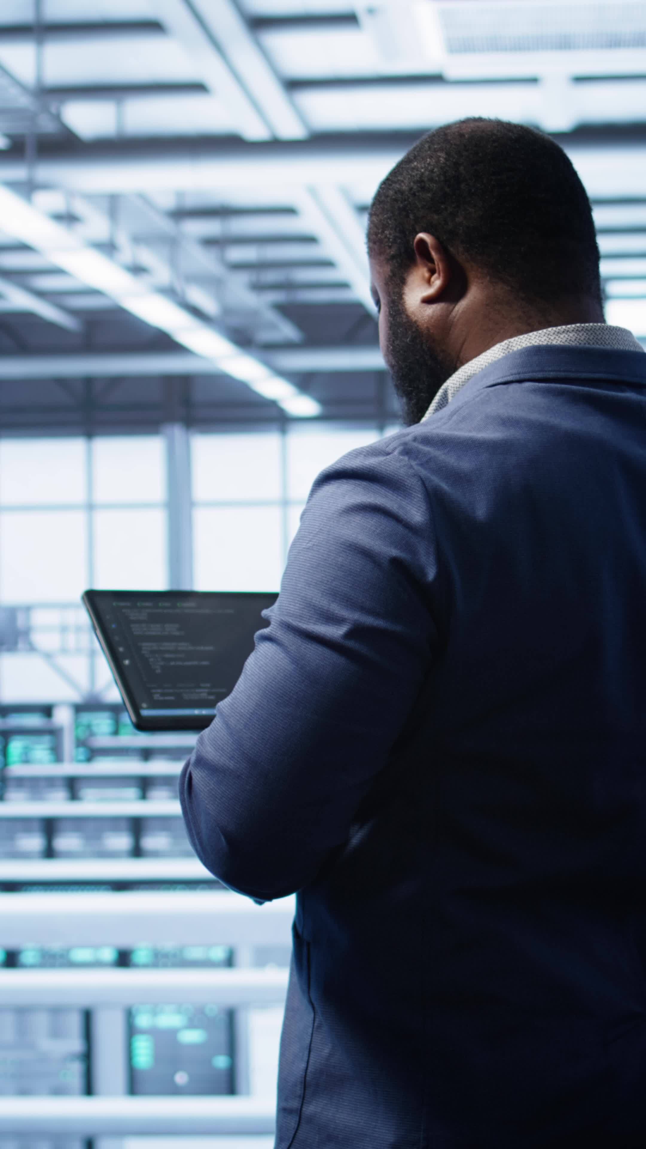 Vertical It Operator In Server Room Workspace Using Tablet To Patch Network Issues Affecting