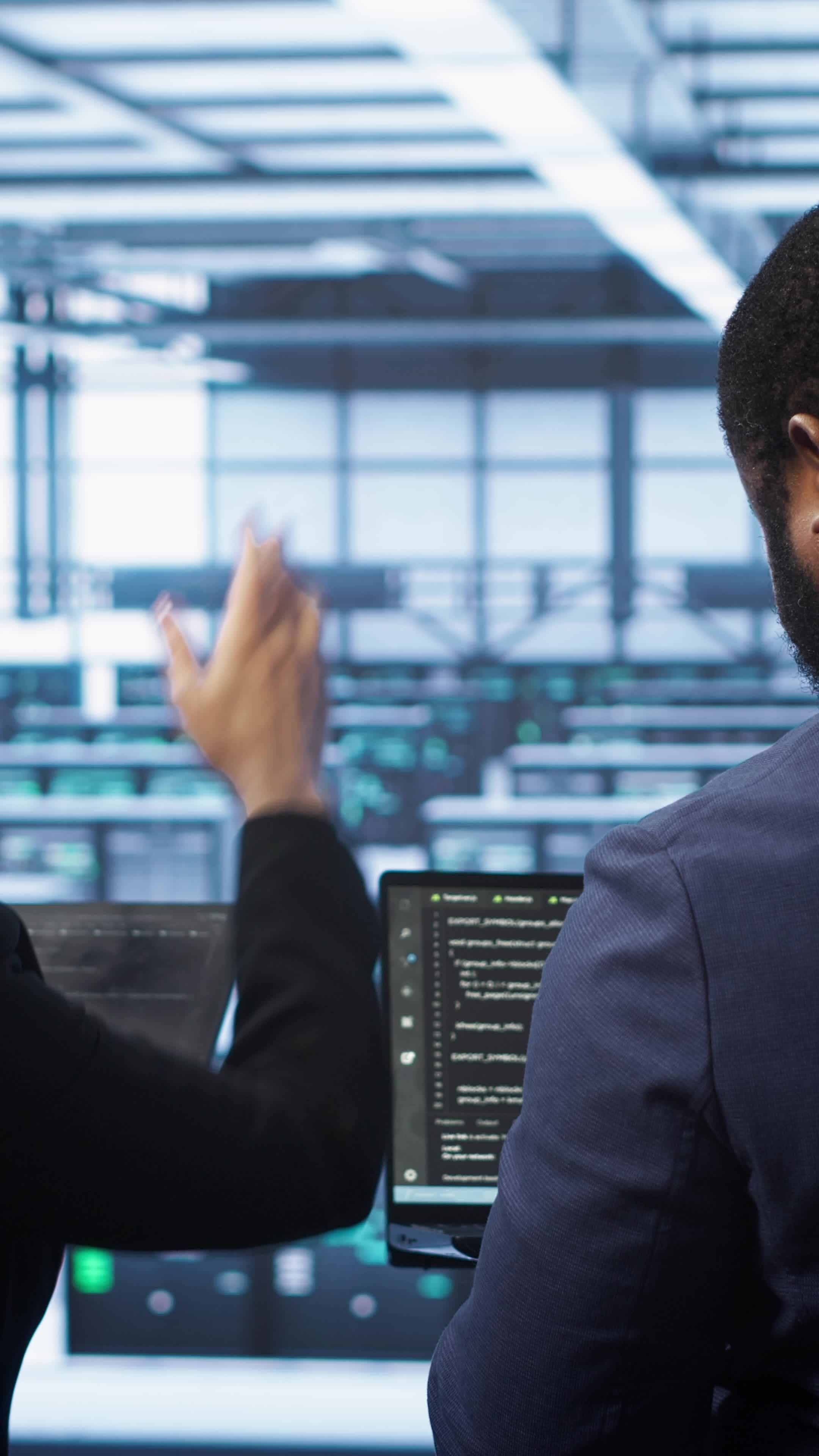 Vertical Teamworking Programmers In Data Center Overseeing Server Operations Using Laptop And