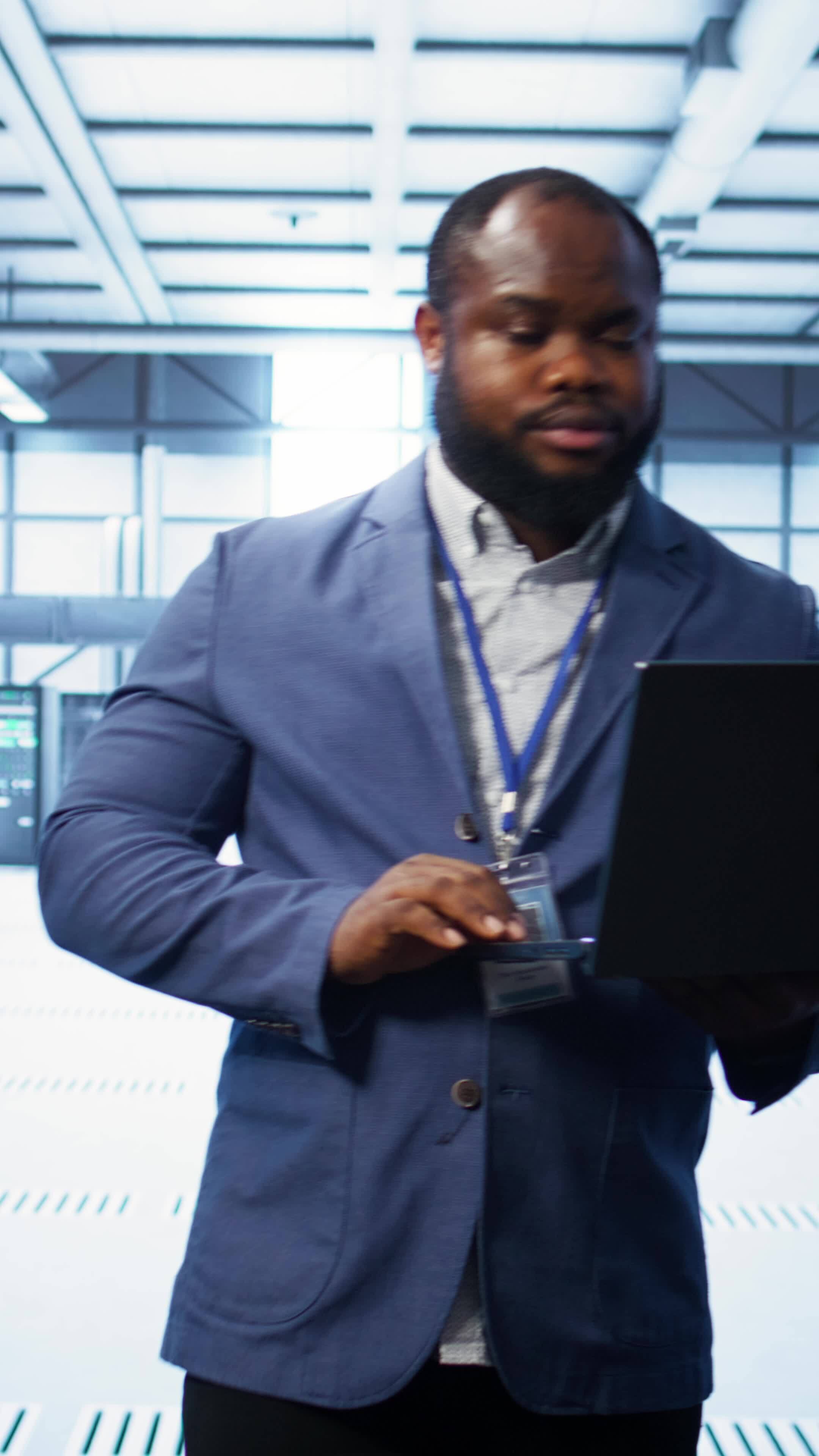 Vertical It Engineer Working On Laptop In Modern Data Center Overseeing Server Operations