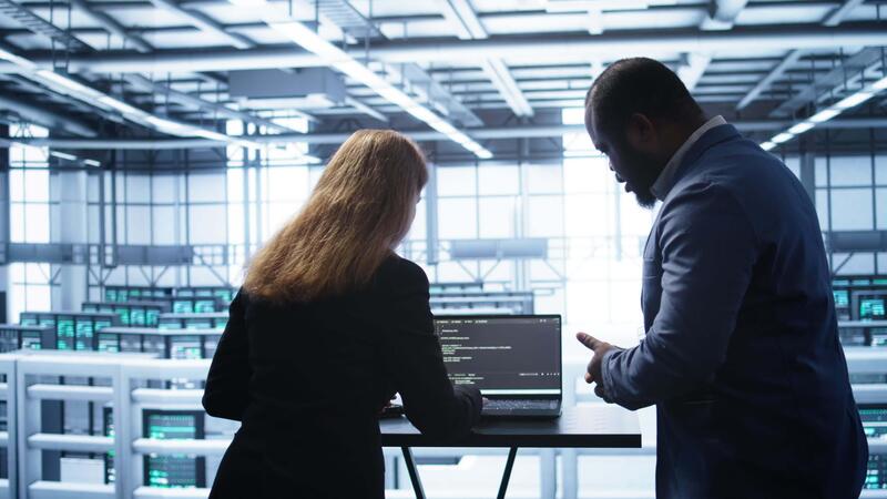 Team of developers doing maintenance checkup using laptop to prolong data center hardware life ...