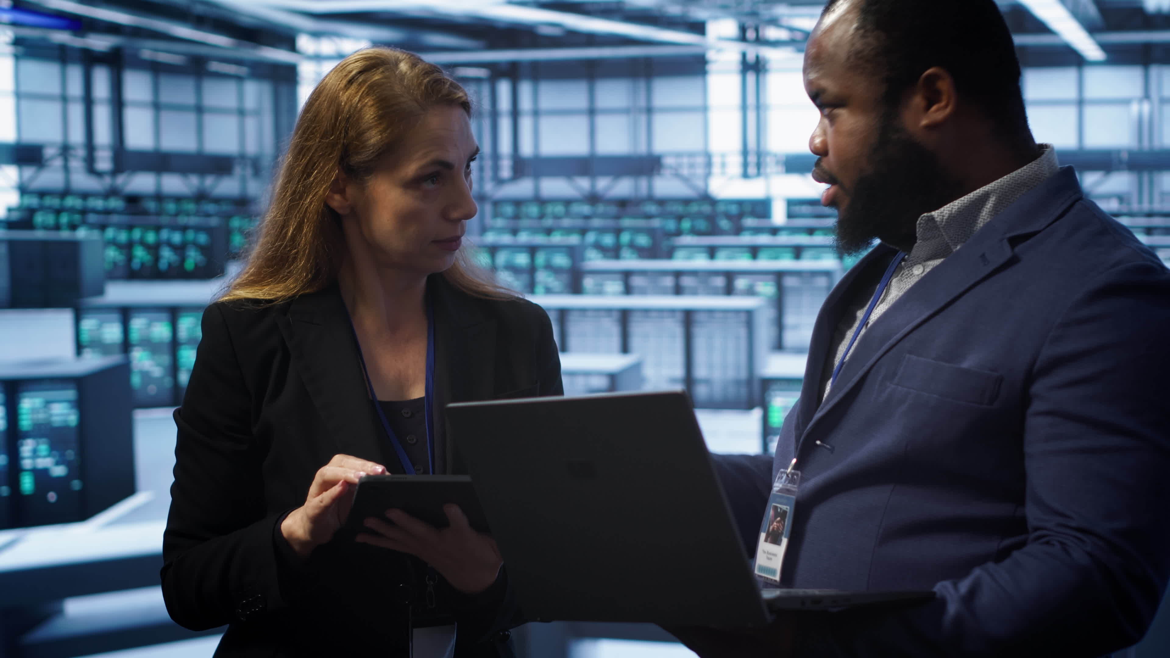 Teamworking Colleagues In Server Farm Using Laptop To Patch Network