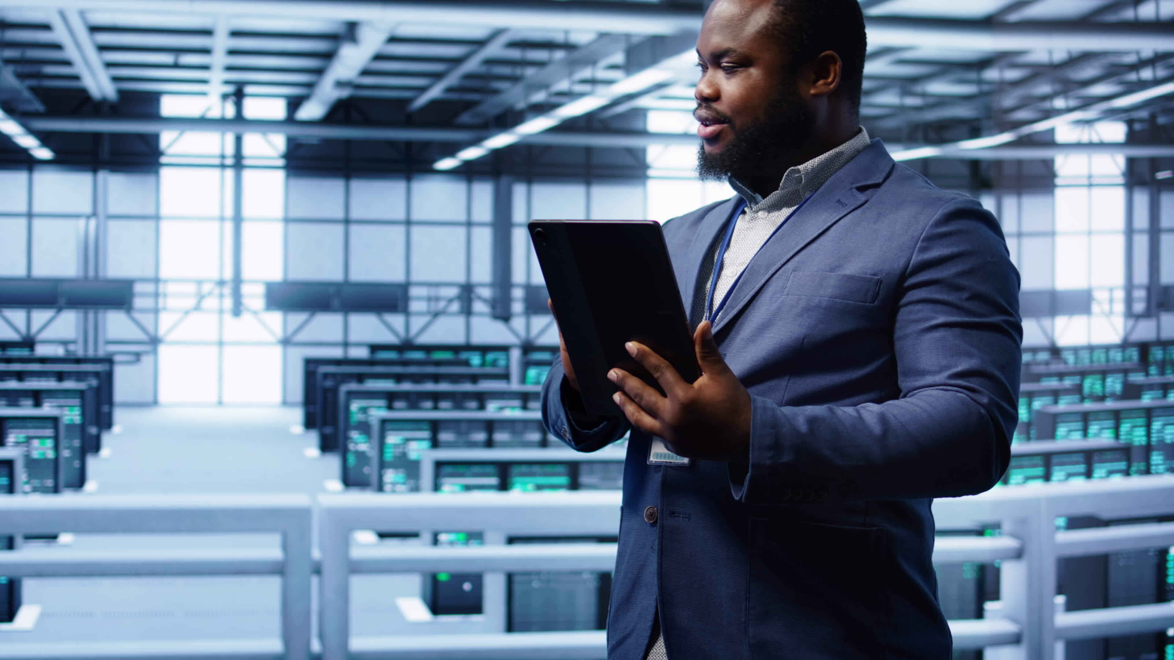 Programmer In Server Room Location Using Tablet To Patch Network Issues Affecting Transfer Rates