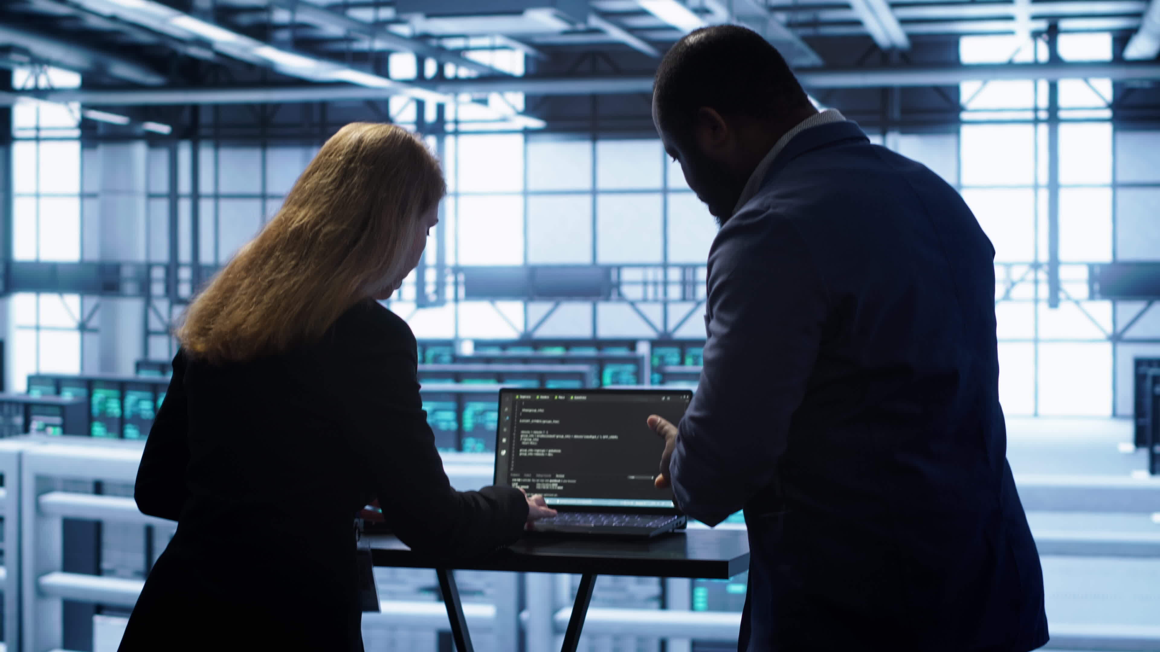 Team of developers doing maintenance checkup using laptop to prolong data center hardware life ...