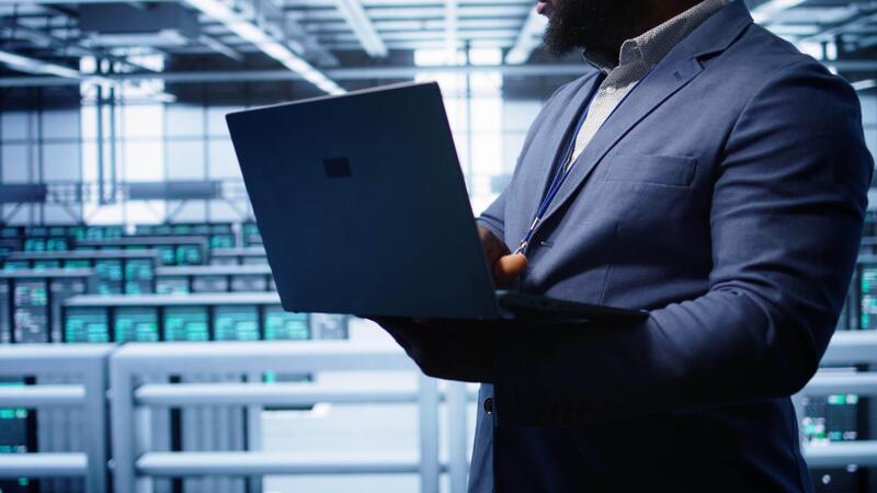 Computer Scientist In High Tech Facility Using Laptop To Patch Network