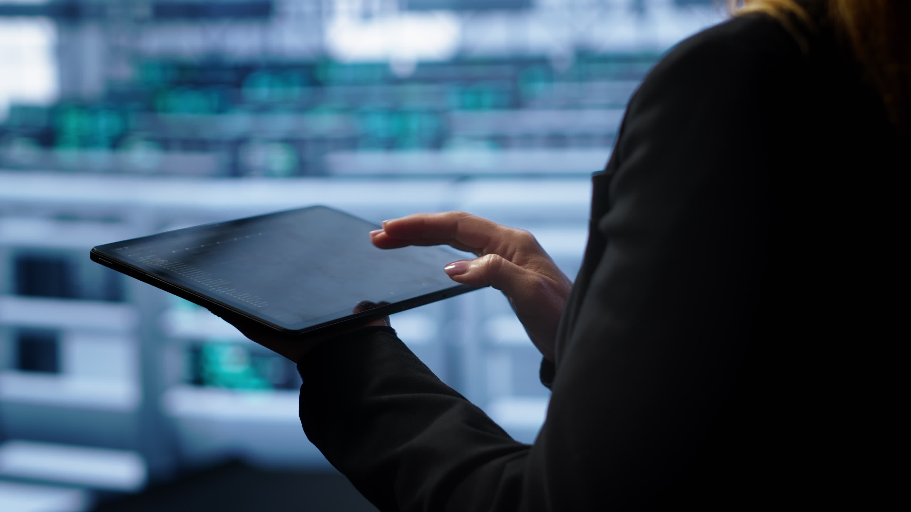 System administrator monitoring server room, doing checkup, inputting data on tablet of needed ...