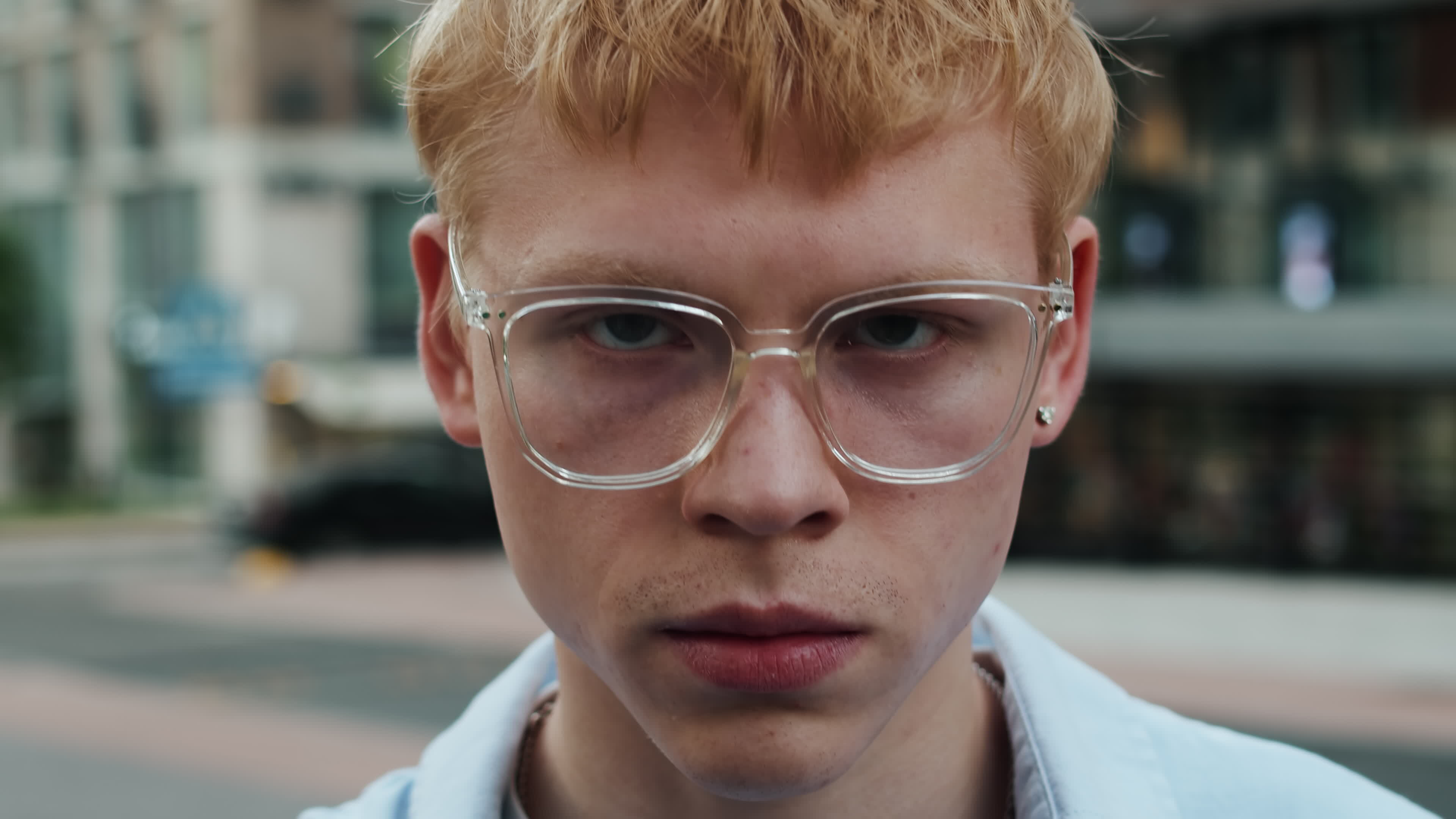 Portrait Of A Young Handsome Caucasian Guy In Glasses Who Raising Her