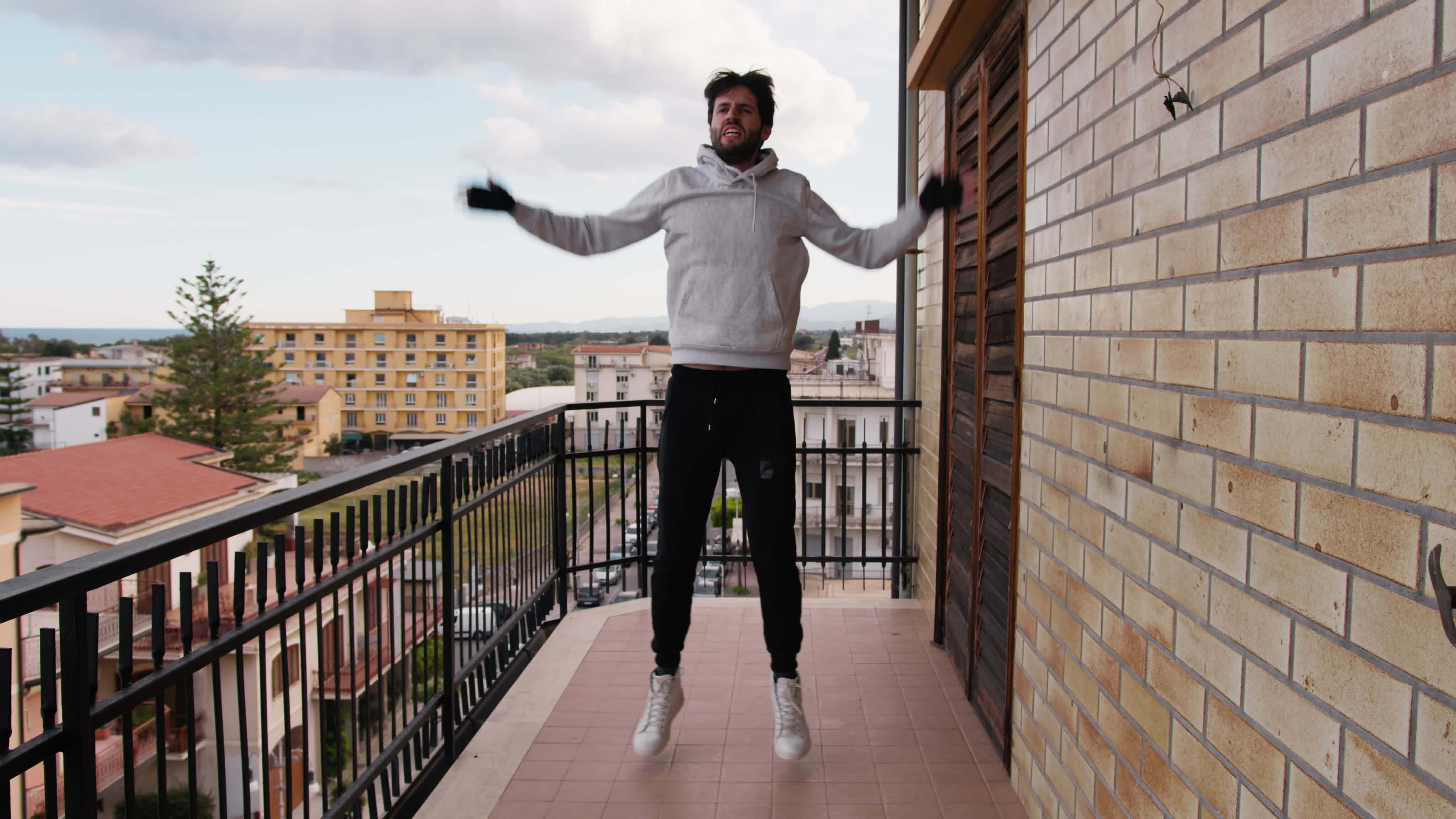 Young Man Jumps Opening And Closing His Arms On The Balcony 46819368 ...