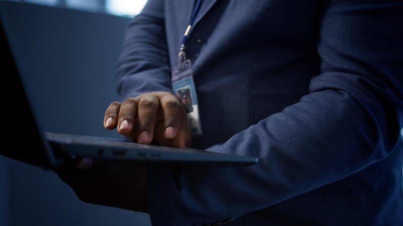 It Technician Working On Notebook In Data Center Overseeing Server Operations Extreme Close Up