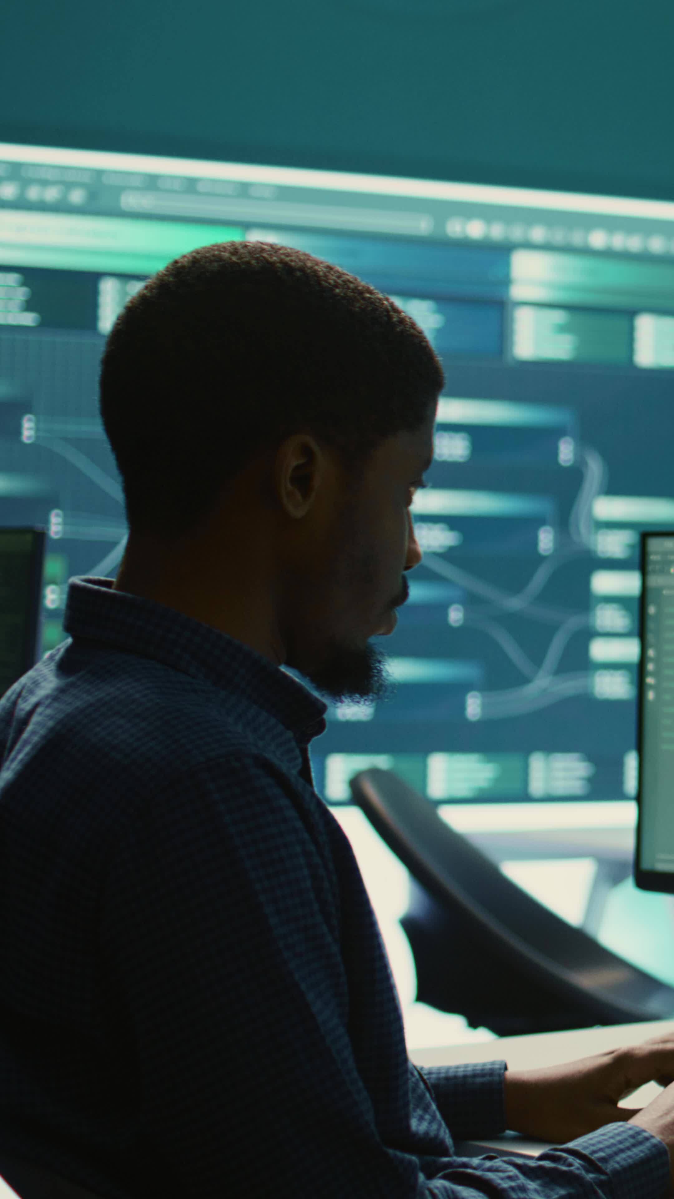 Vertical Governmental Hackers Analyzing Data For Cyber Threat Detection Looking At A Big Screen