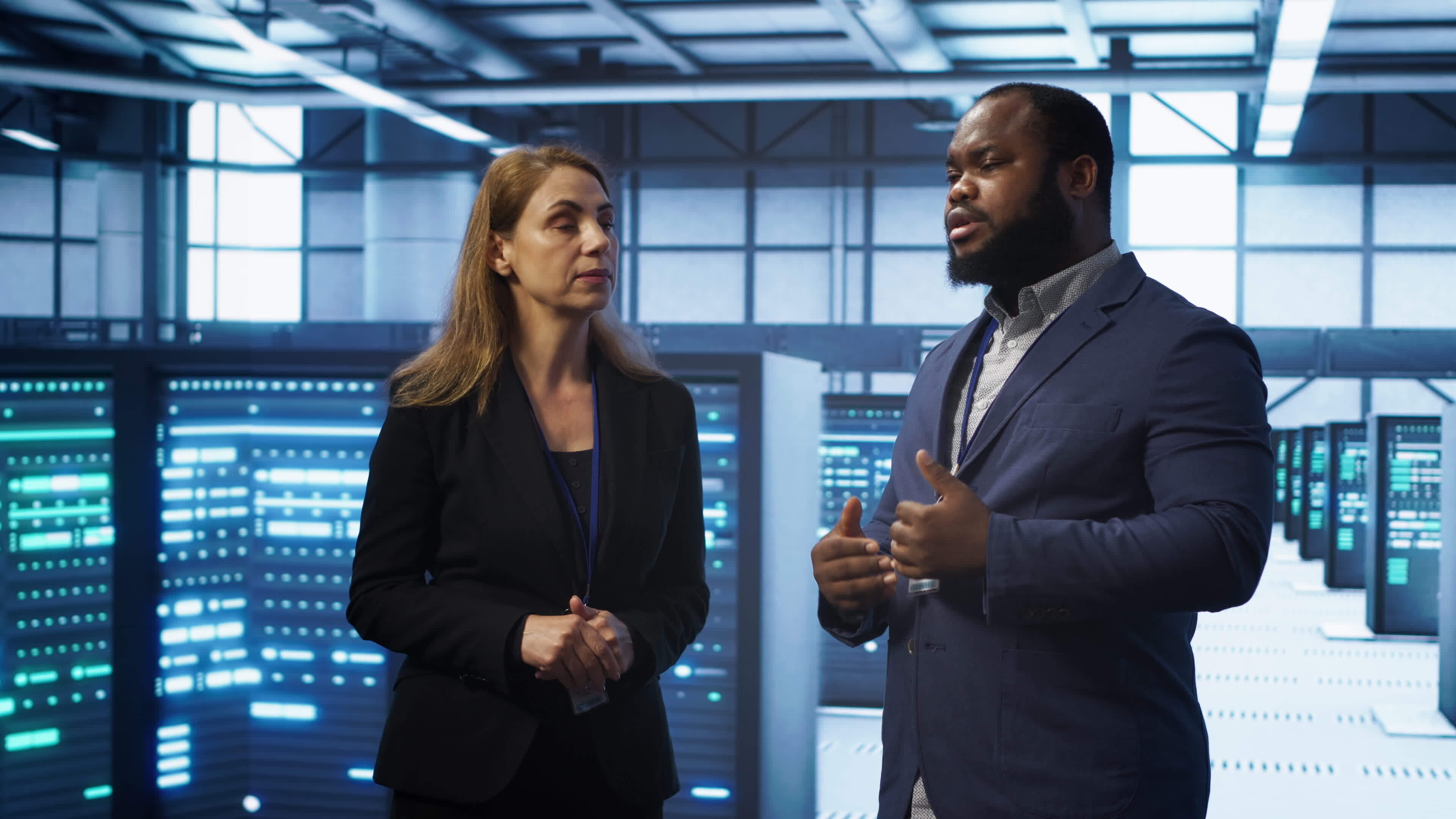 Teamworking technicians in high tech data center workspace looking at hologram visualization ...