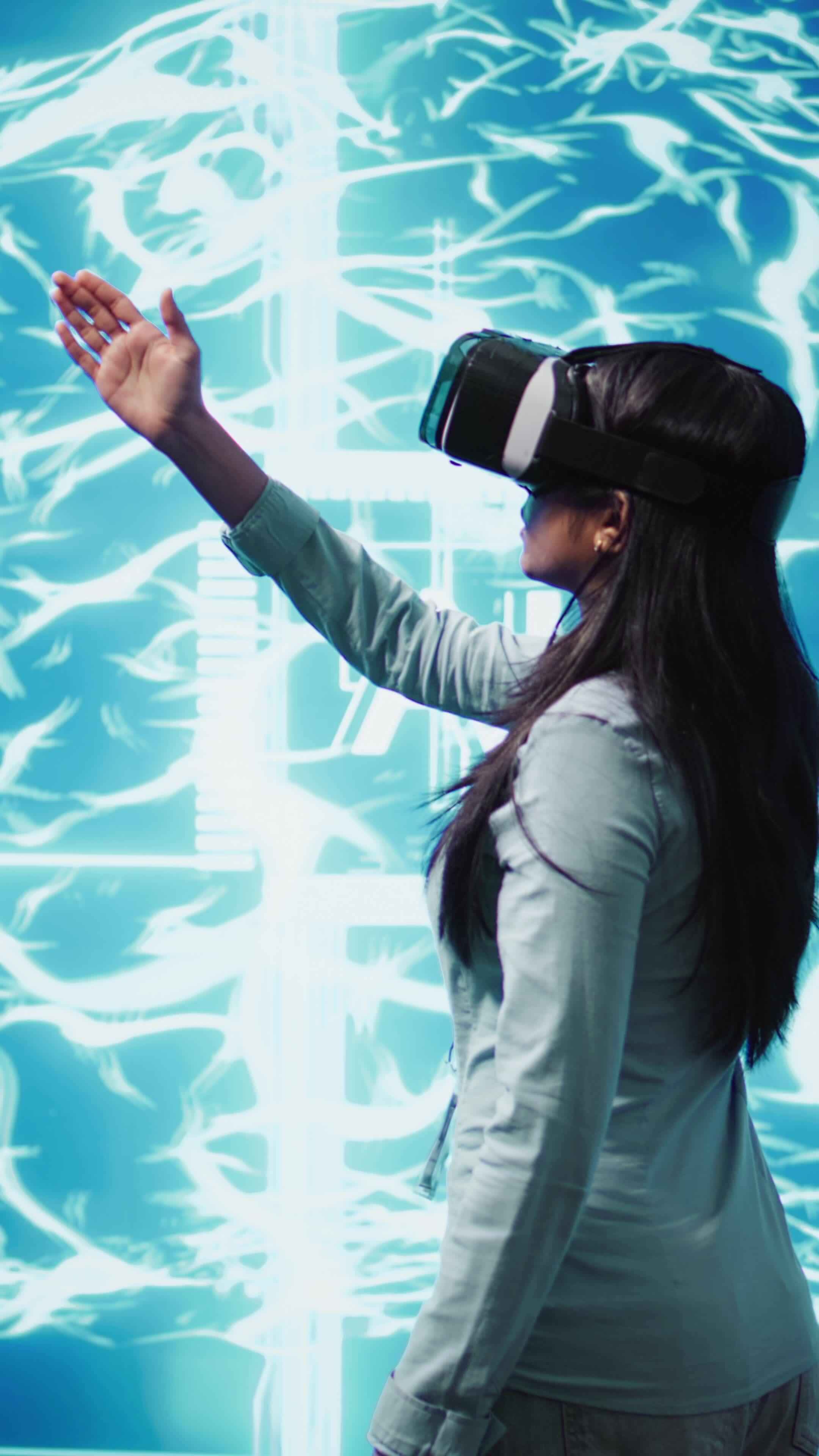 Vertical Developer wearing VR headset looking at hologram of artificial ...