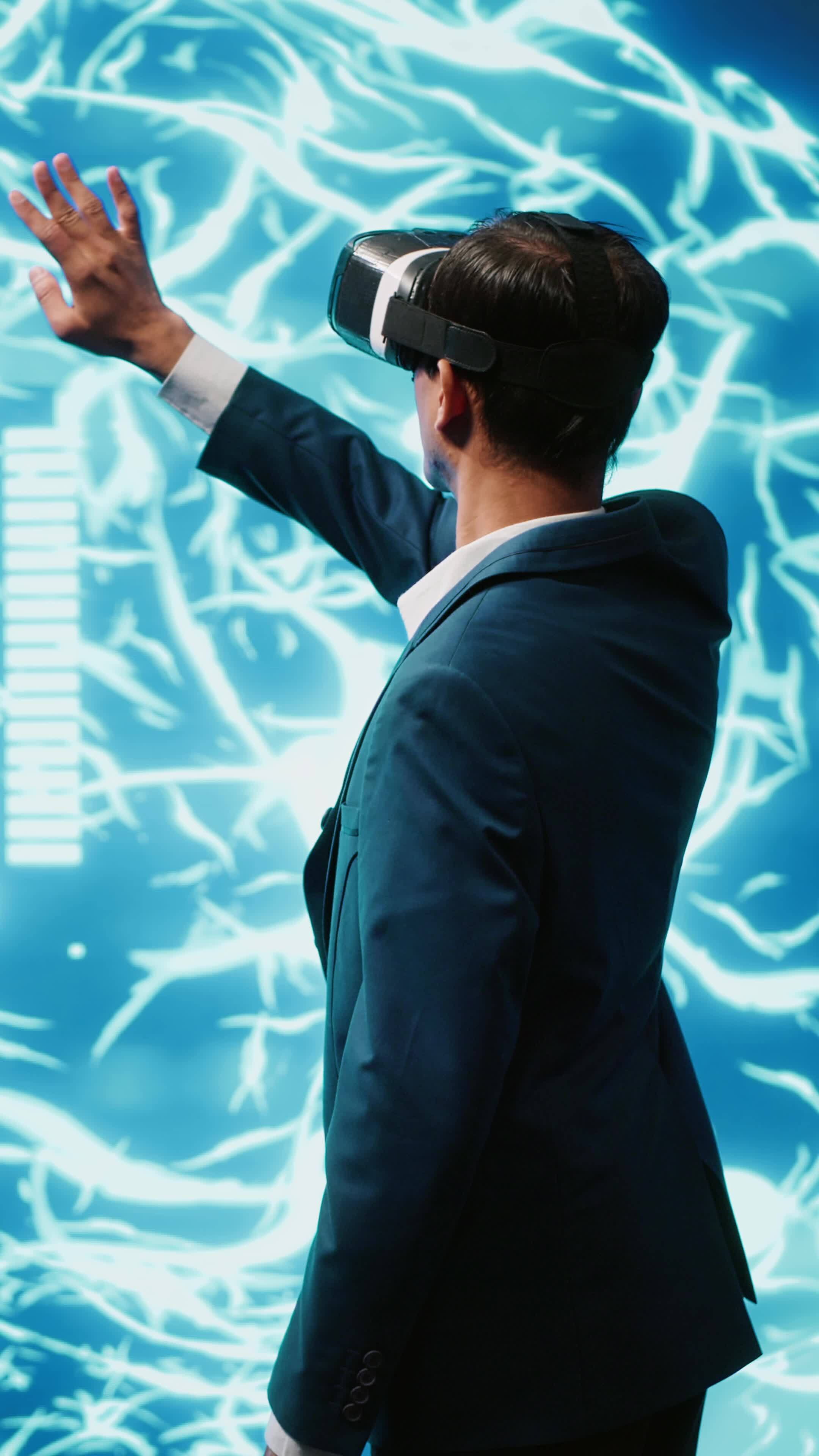 Vertical Computer scientist wearing VR headset looking at hologram of ...