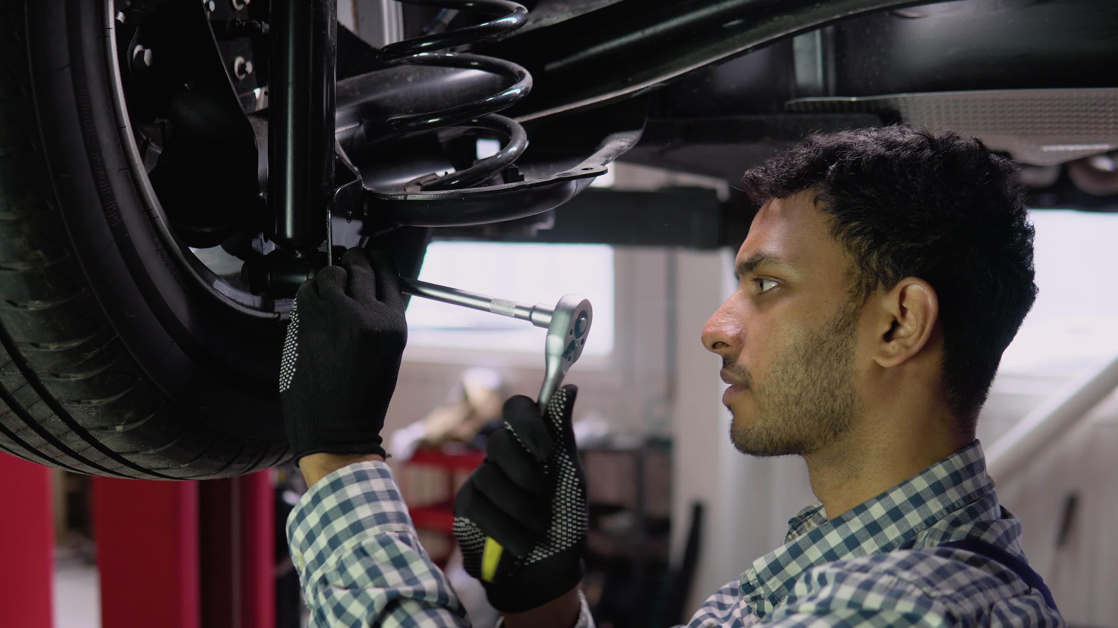 Indian or pakistani auto mechanic working under car on hydraulic lift ... Indian or pakistani auto mechanic working under car on hydraulic lift ...