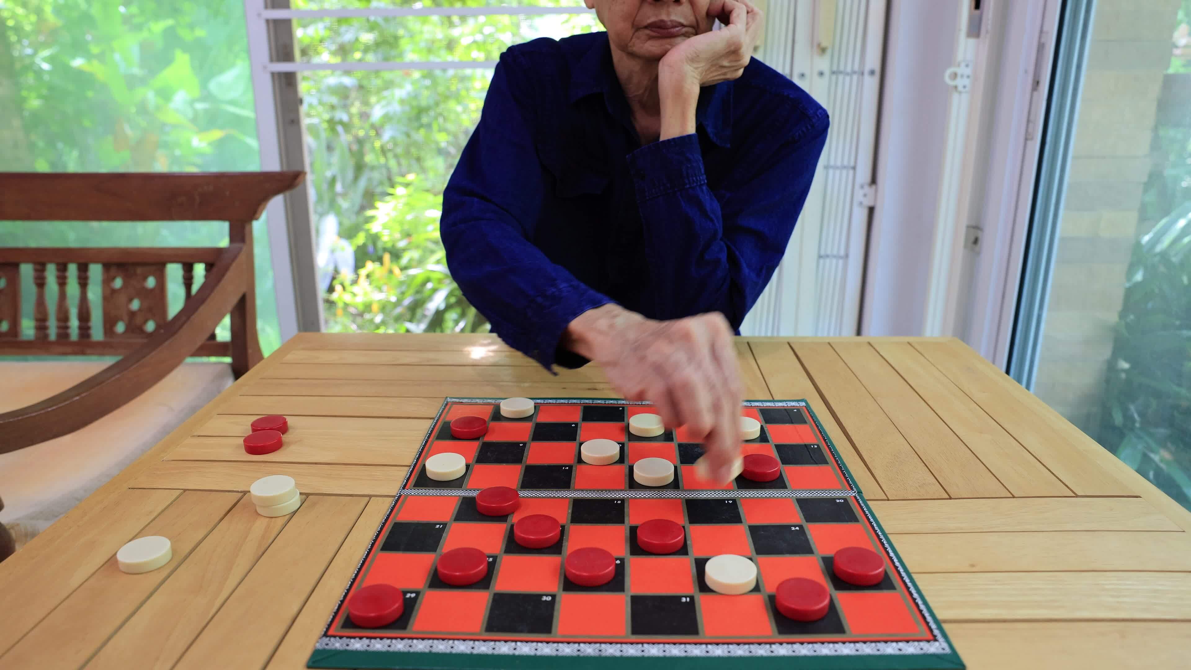 Senior asian father and son are enjoy playing checkers board game at ...
