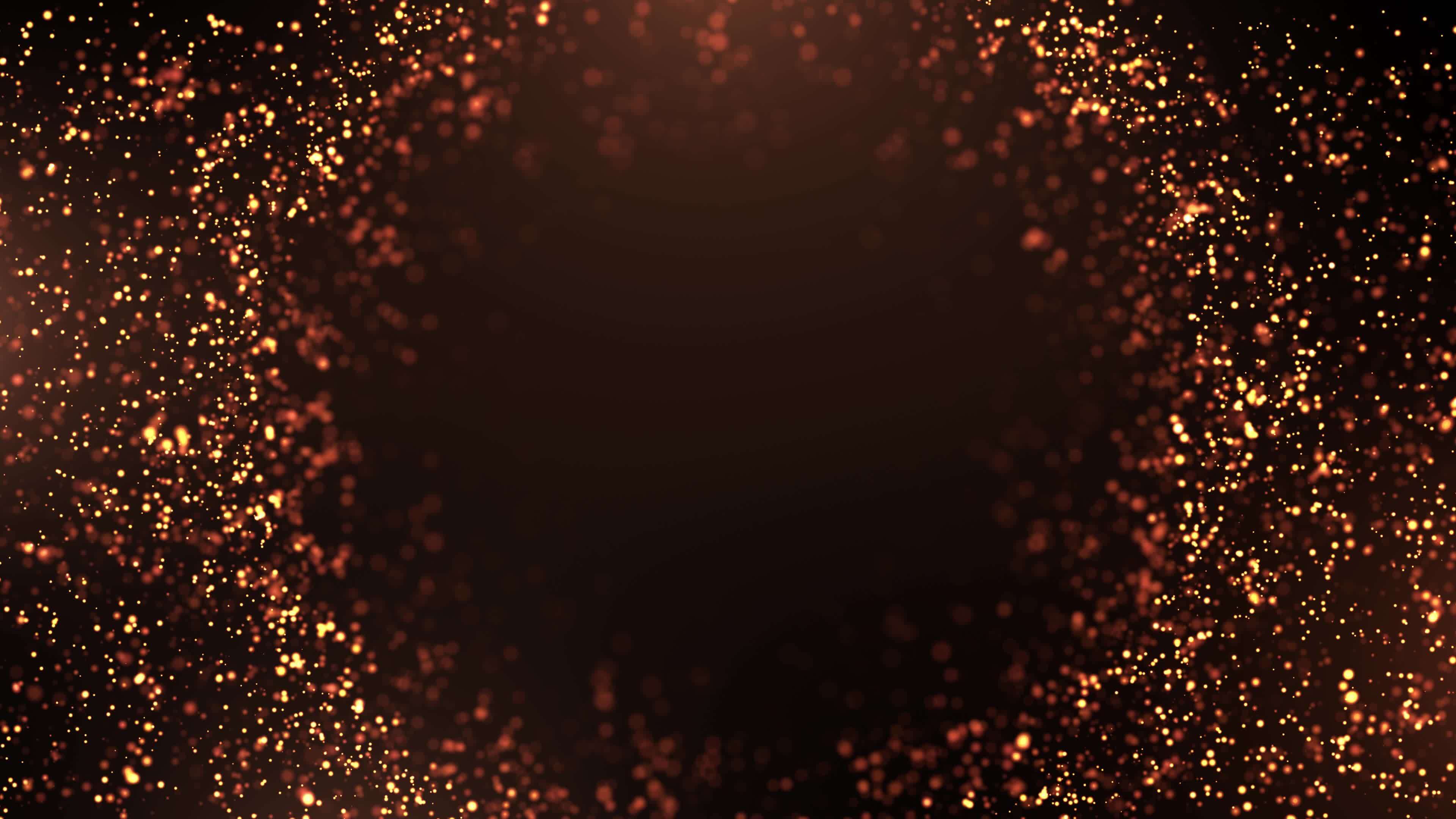 Abstract round sphere of shiny orange-gold dust particles with magical glow on a dark background ...