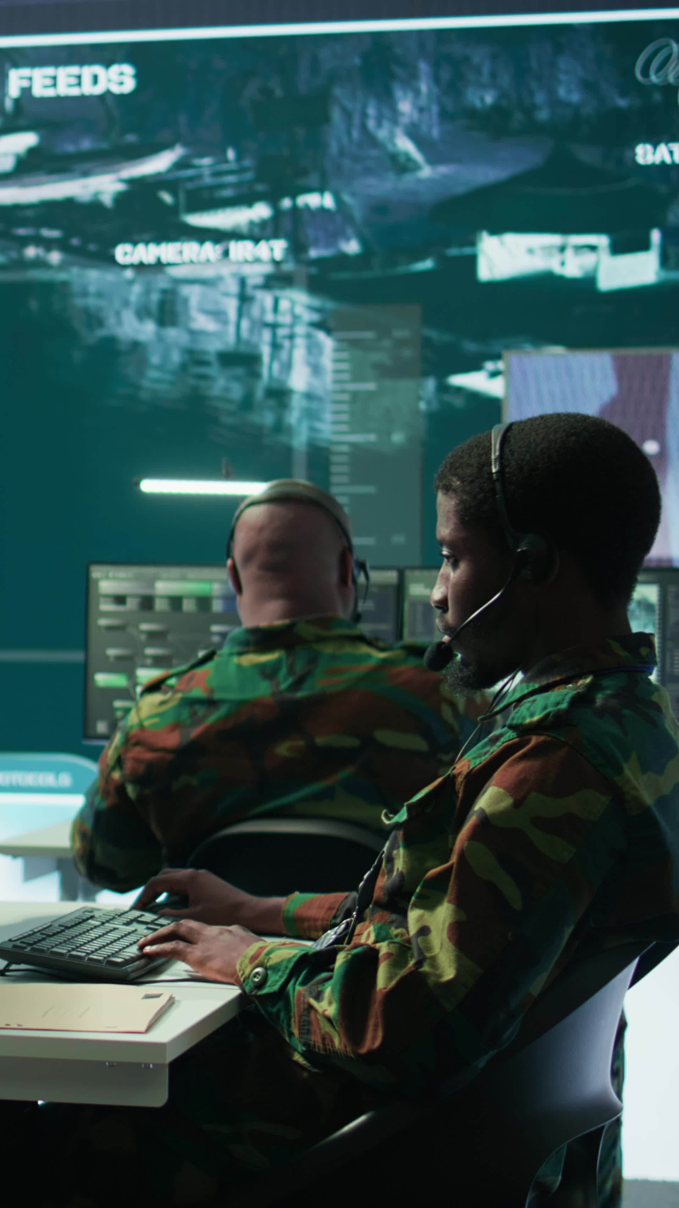 Vertical Team of military specialists in command post monitoring ...