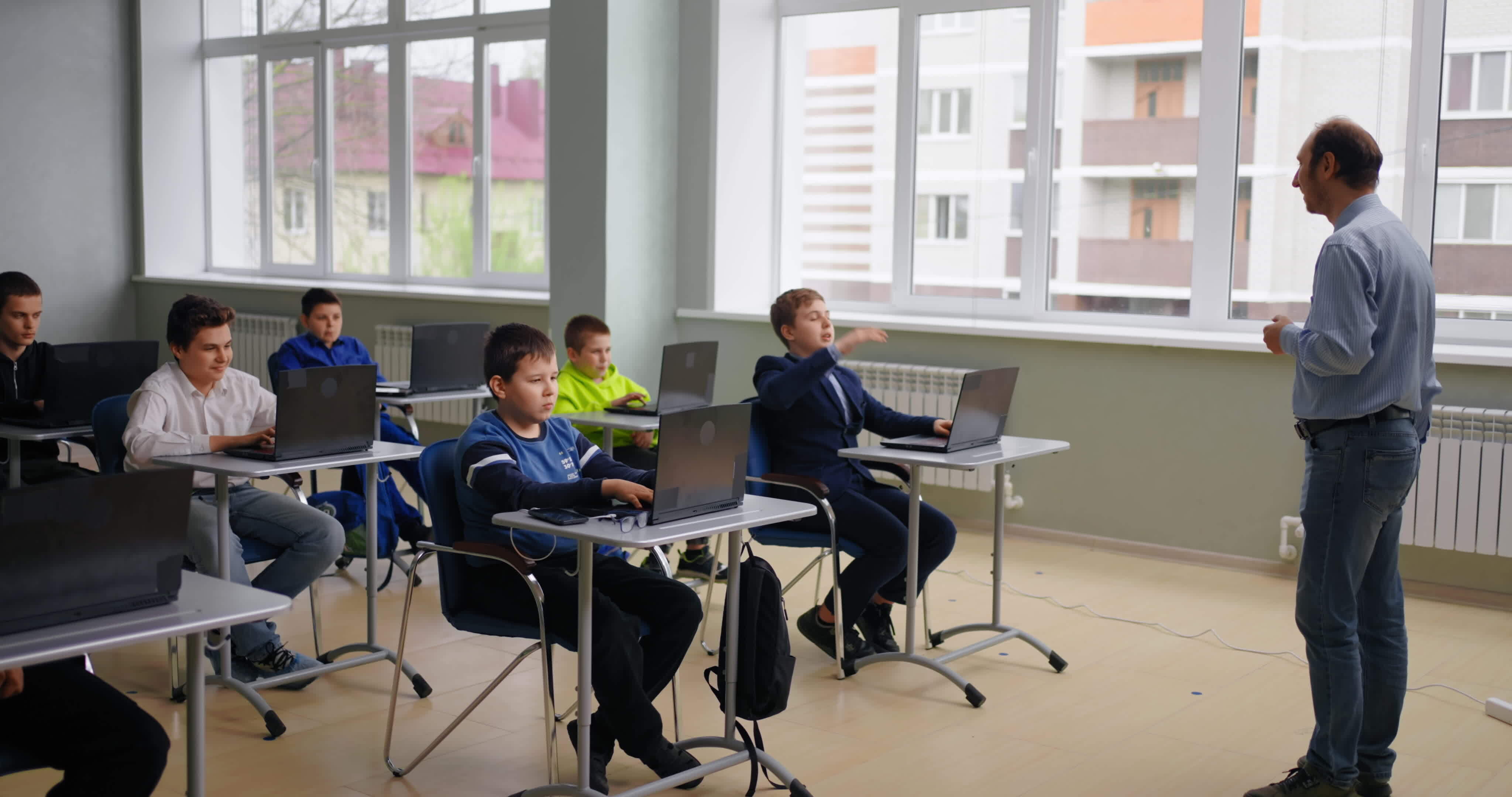 Young School Students Sitting At Tables With Laptops In Computer-Based ...