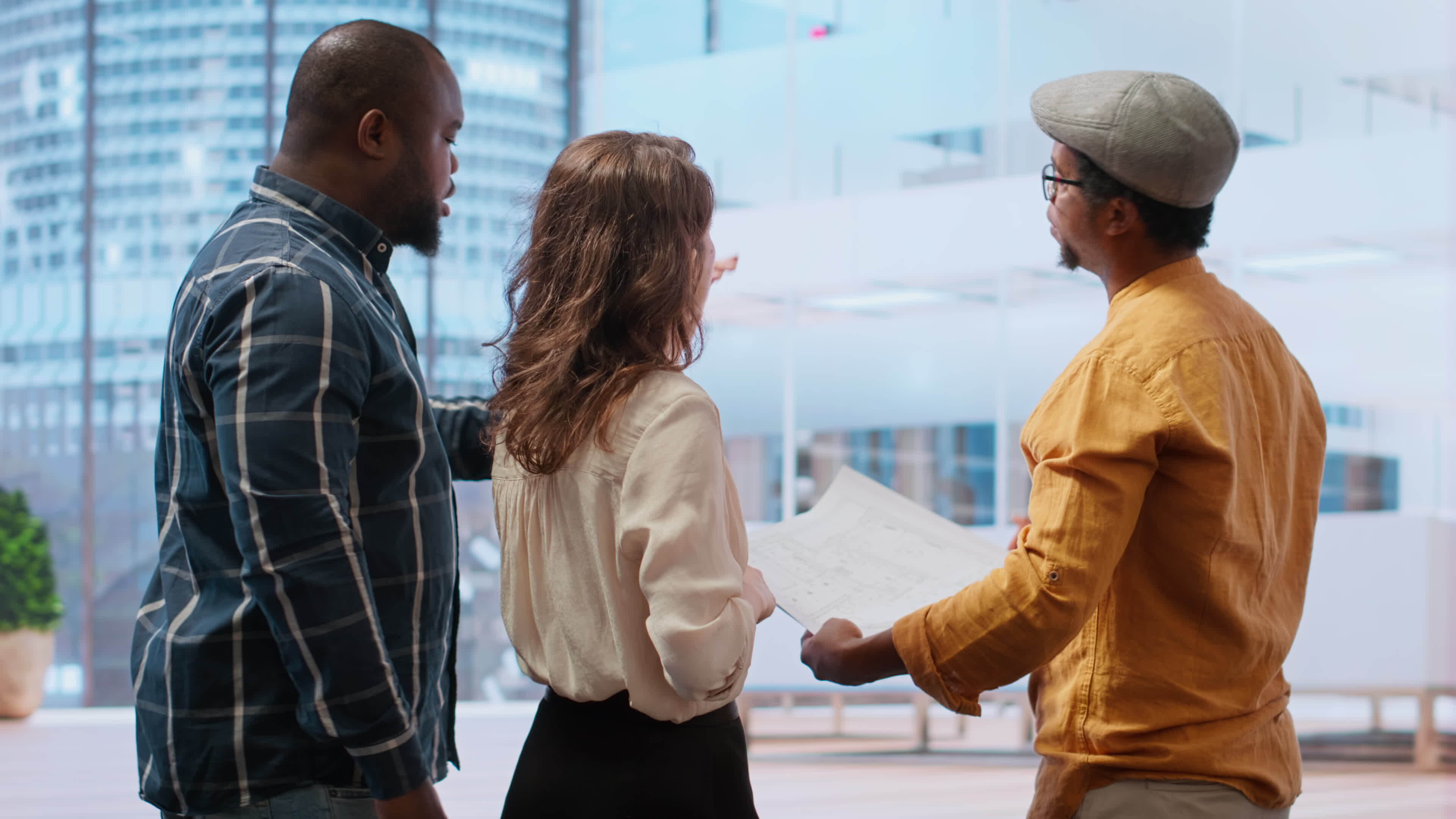 Realtor And Clients Sharing Workspace Design Vision On Office Tour