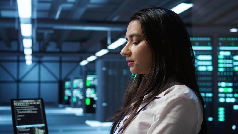 Programmer In Data Center Typing On Computer Keyboard Ensuring System Can Handle Networking